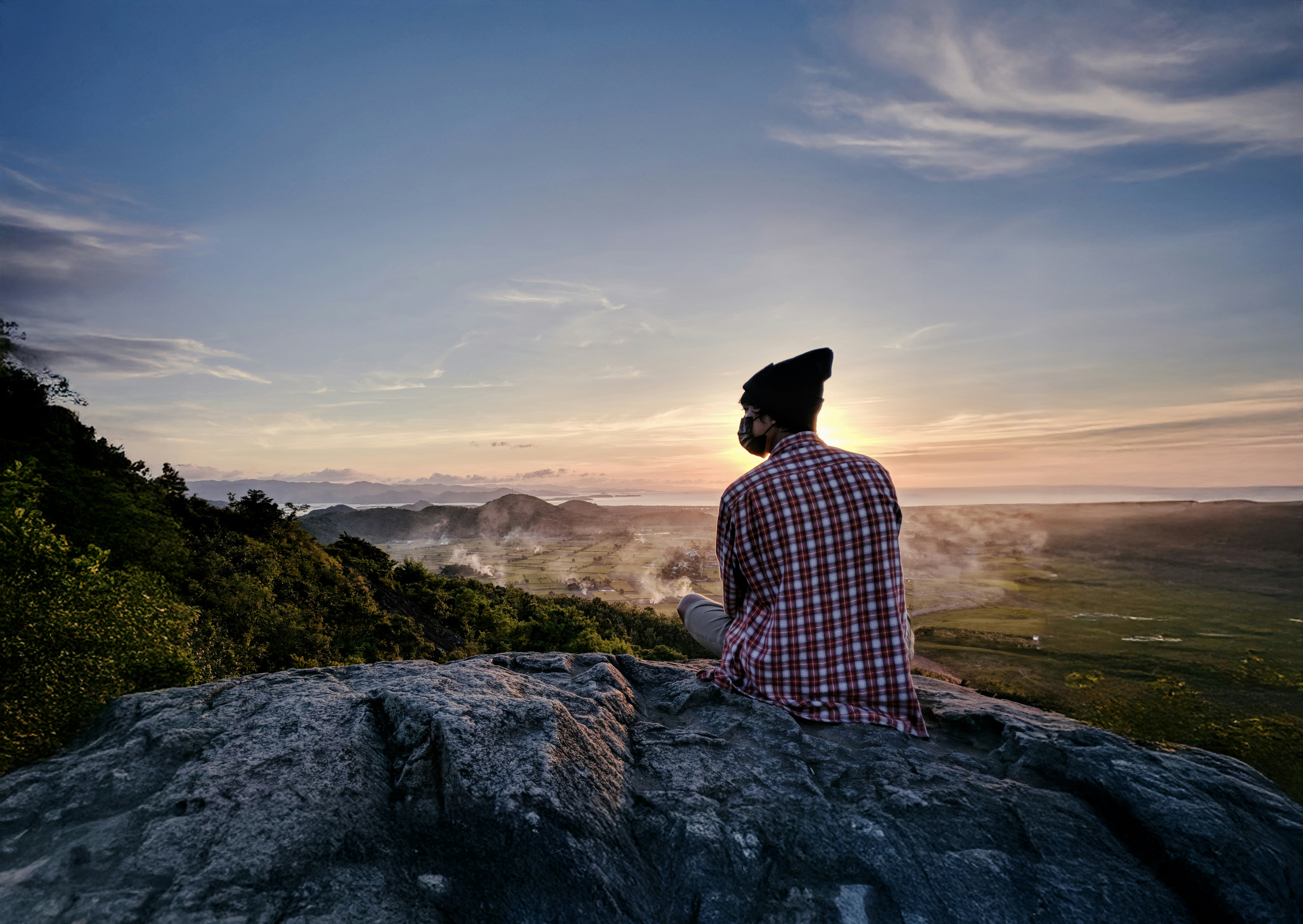 A man sitting on top of a large rock photo – Free Gunung batu idung ...