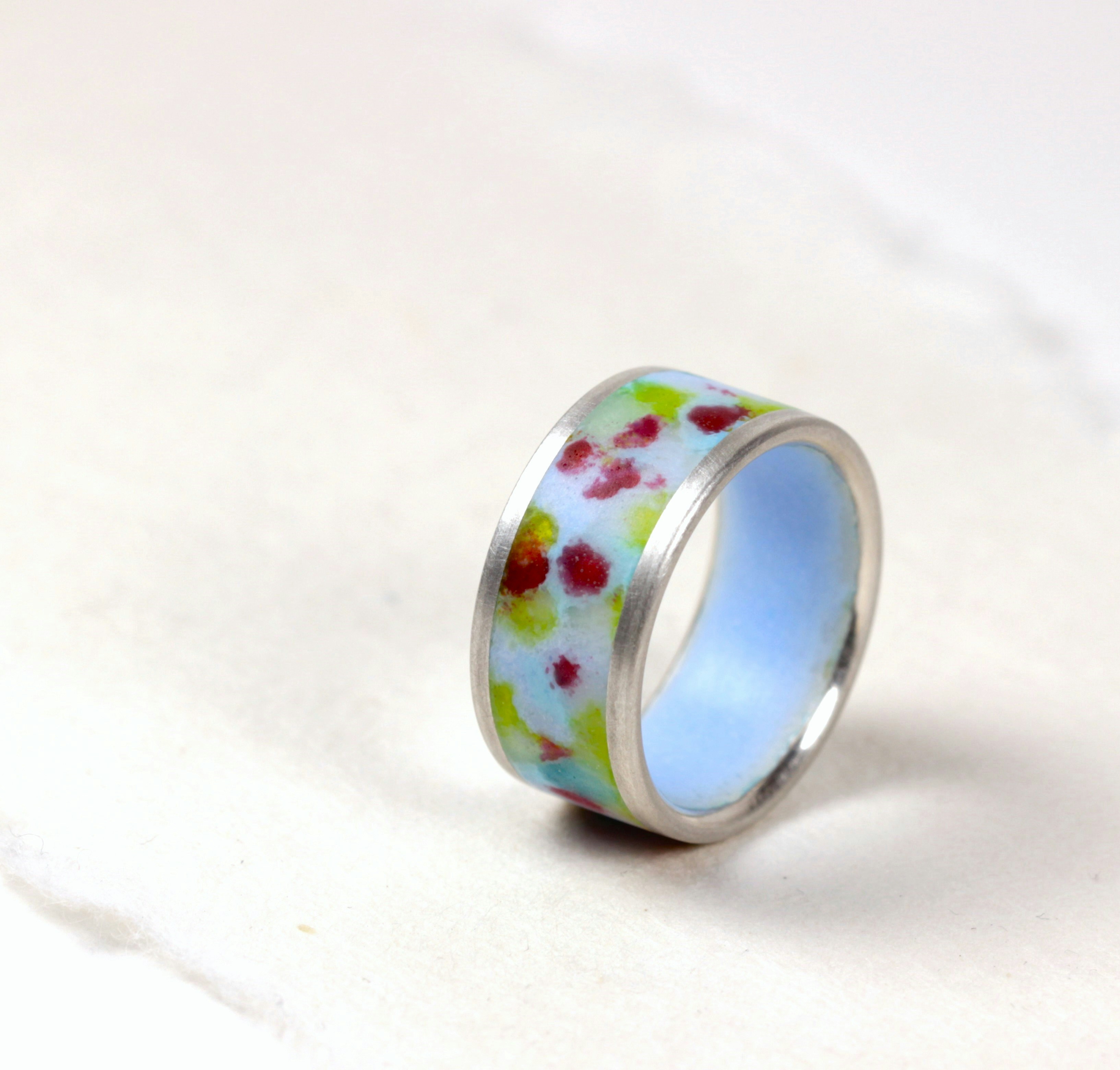 Polished Ring with Multicolored Inlay Resting on Soft Fabric