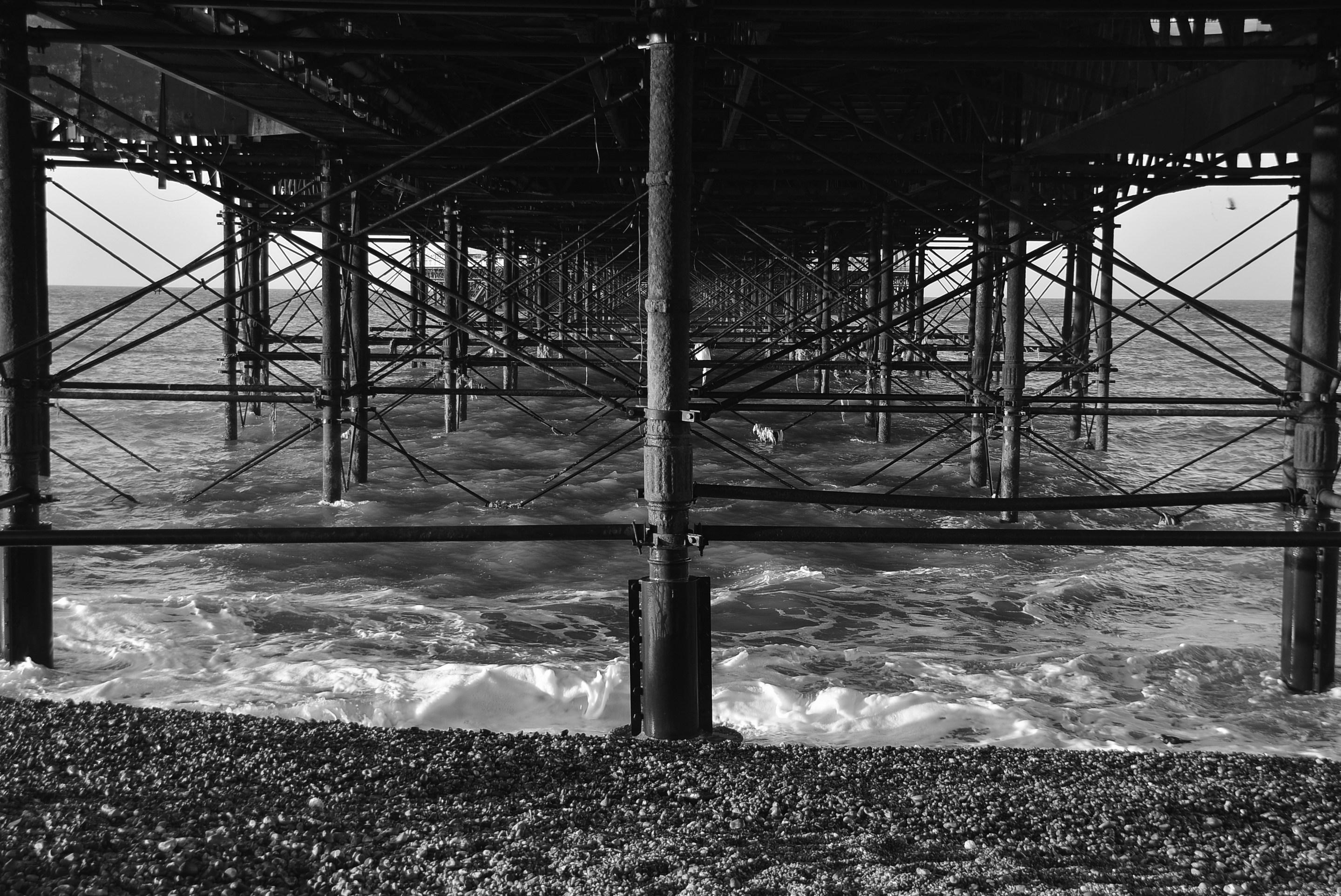 Lattice of Steel and Tide Beneath the Pier