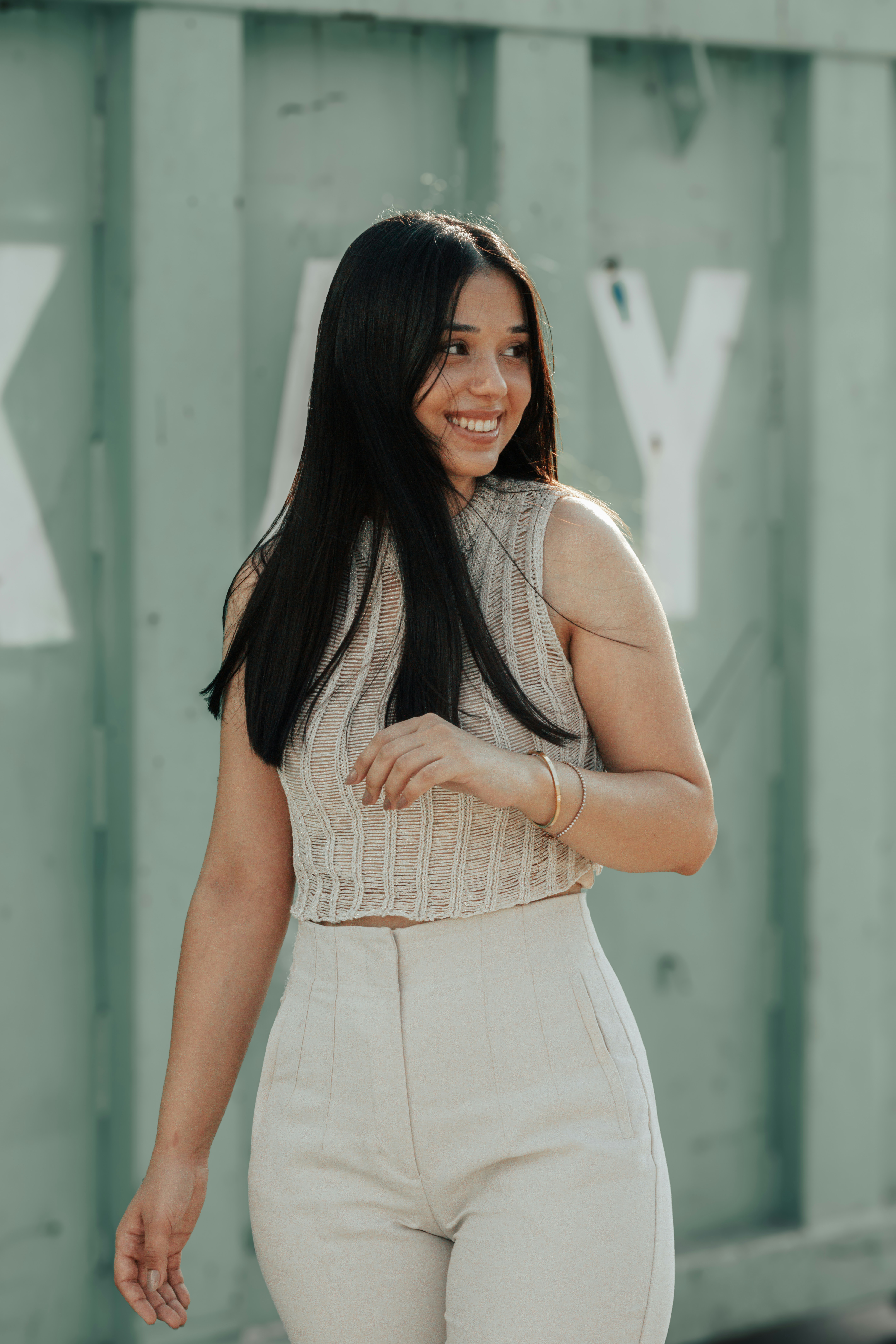A woman in a crop top and pants smiling photo – Free Person Image on ...