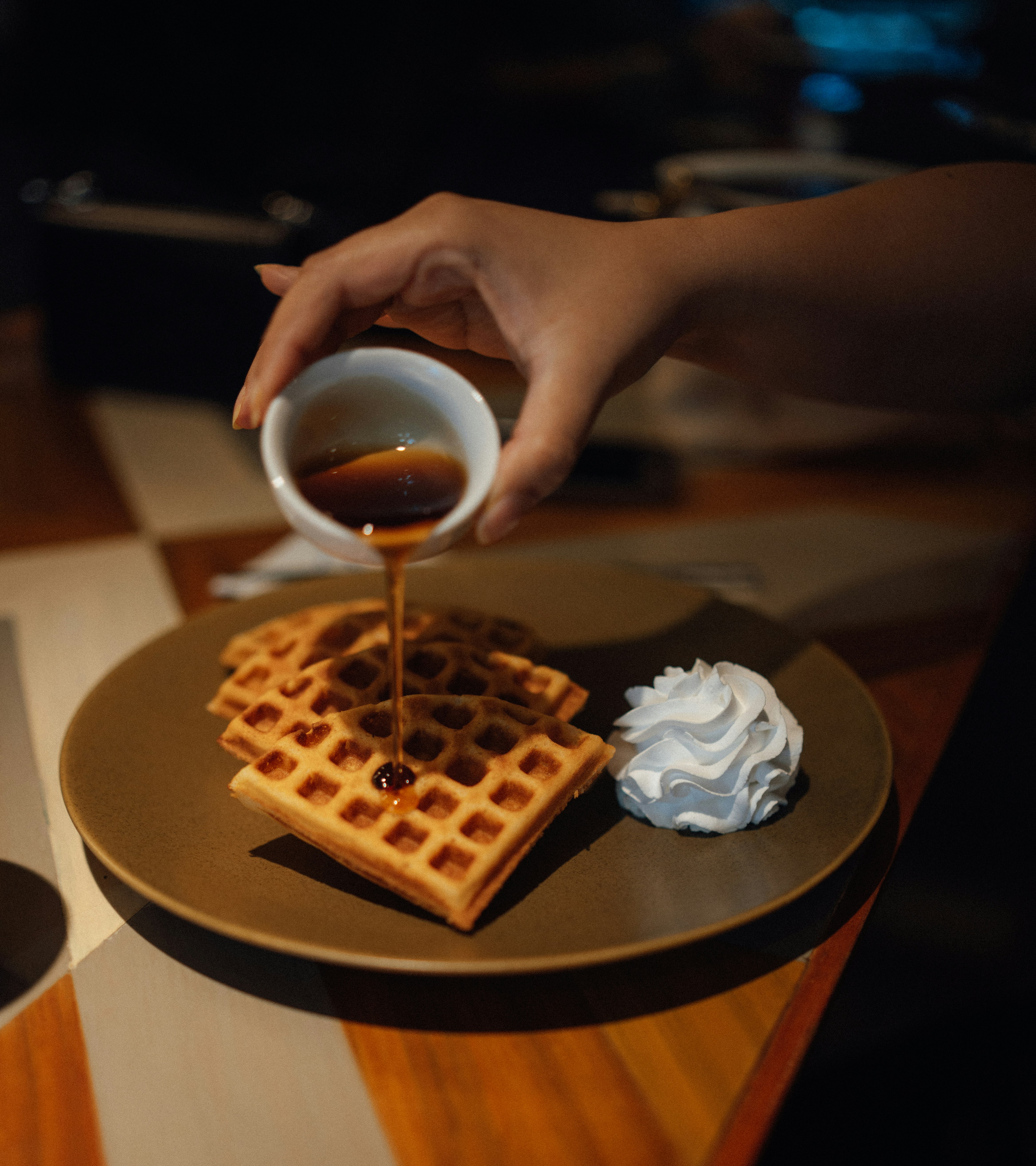 Golden Pour: Coffee Syrup Drips onto a Waffle with Whipped Cream
