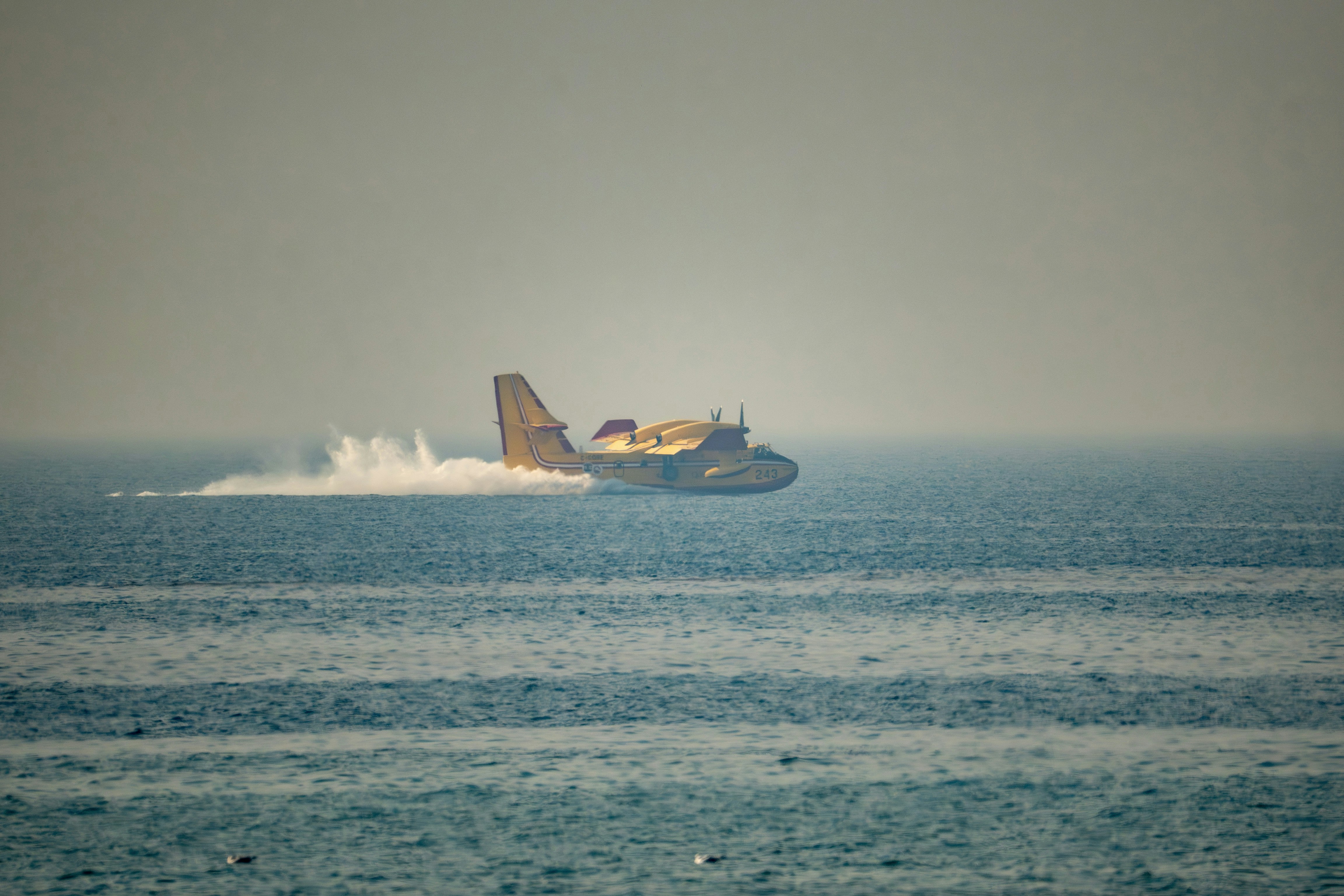 A plane is flying low over the ocean photo – Free Current events Image ...