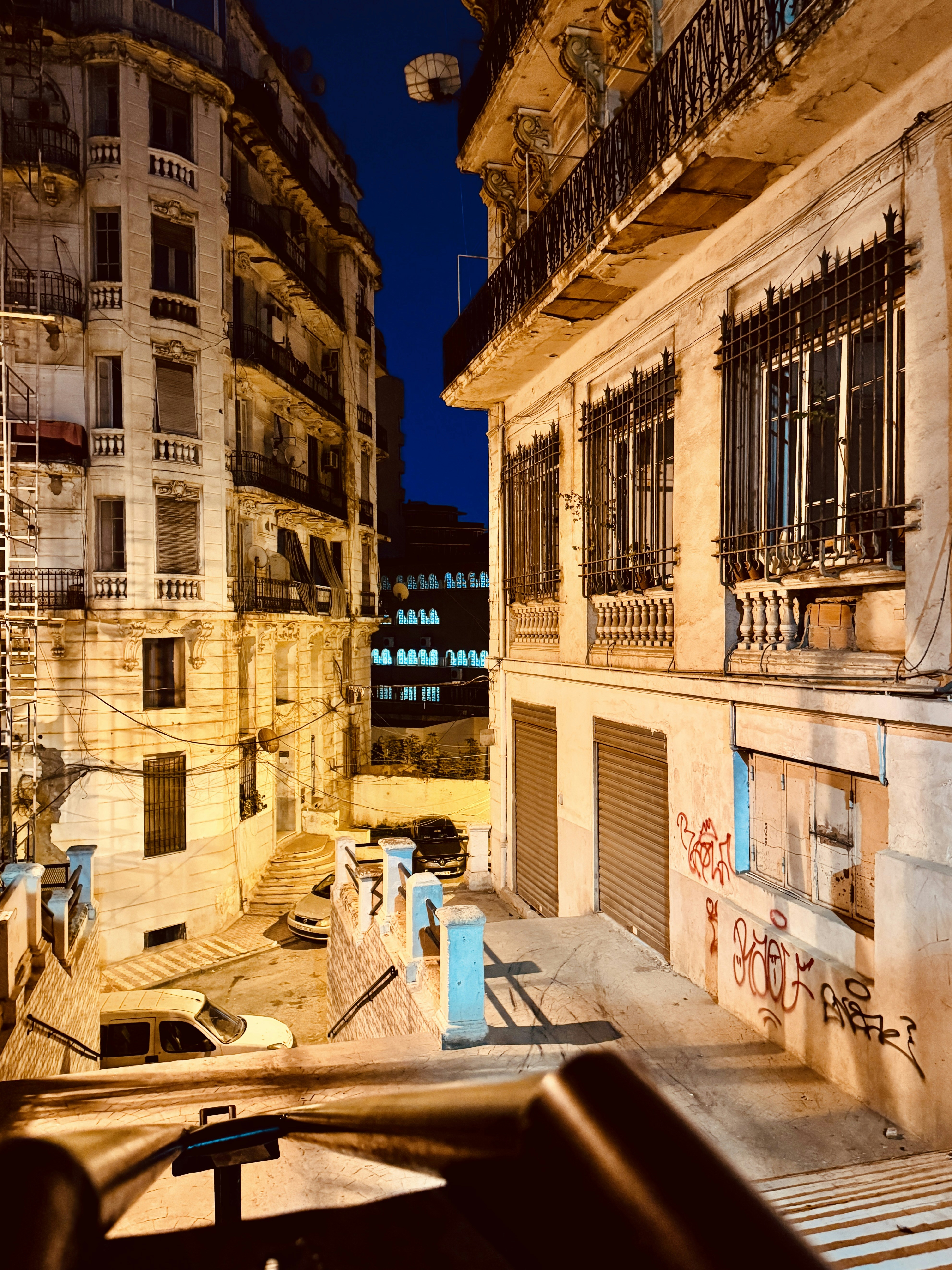 Amber Alleyway at Night: Weathered Facades Meet a Distant Blue Glow
