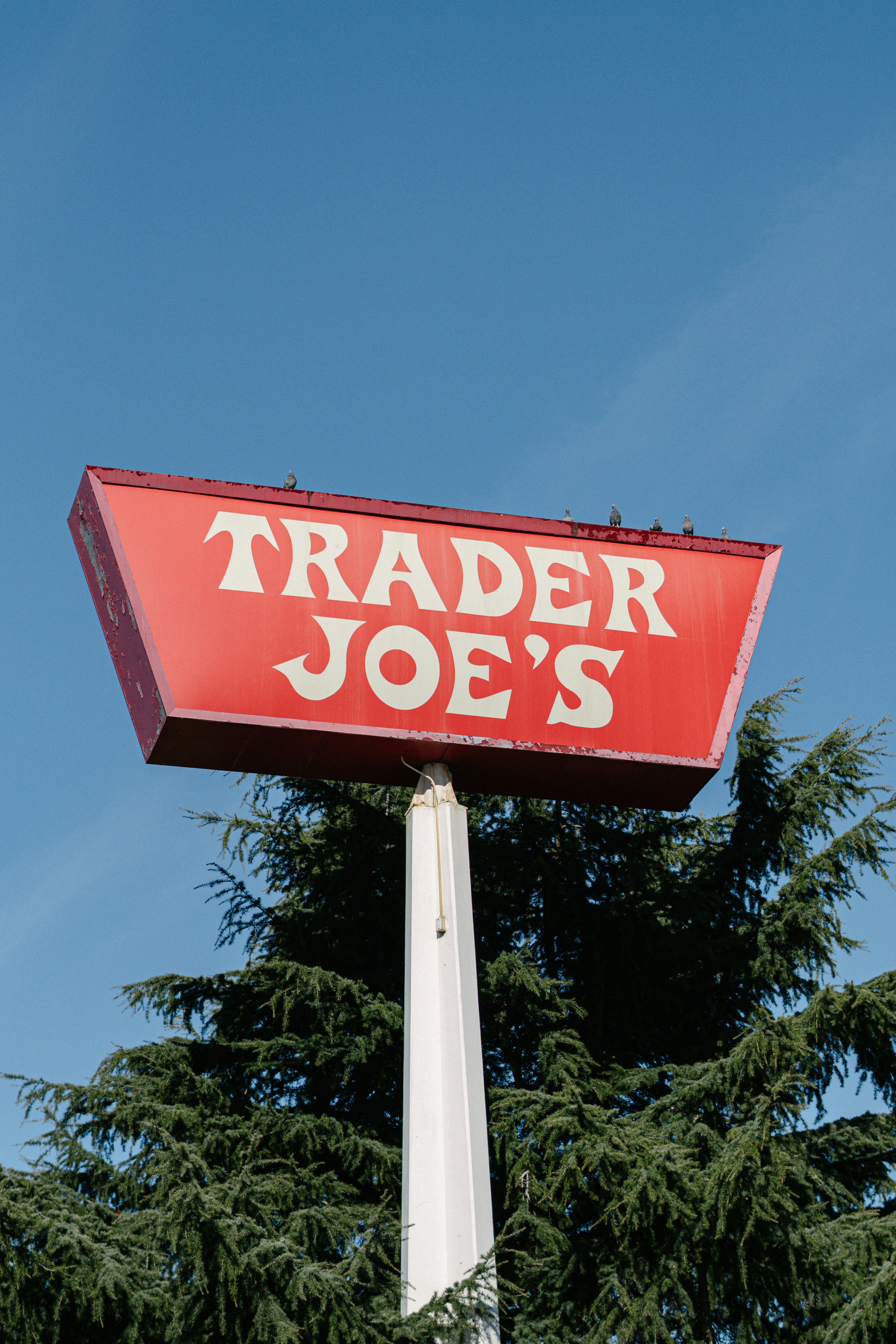 A red trader joe's sign on top of a pole photo – Free Red Image on Unsplash