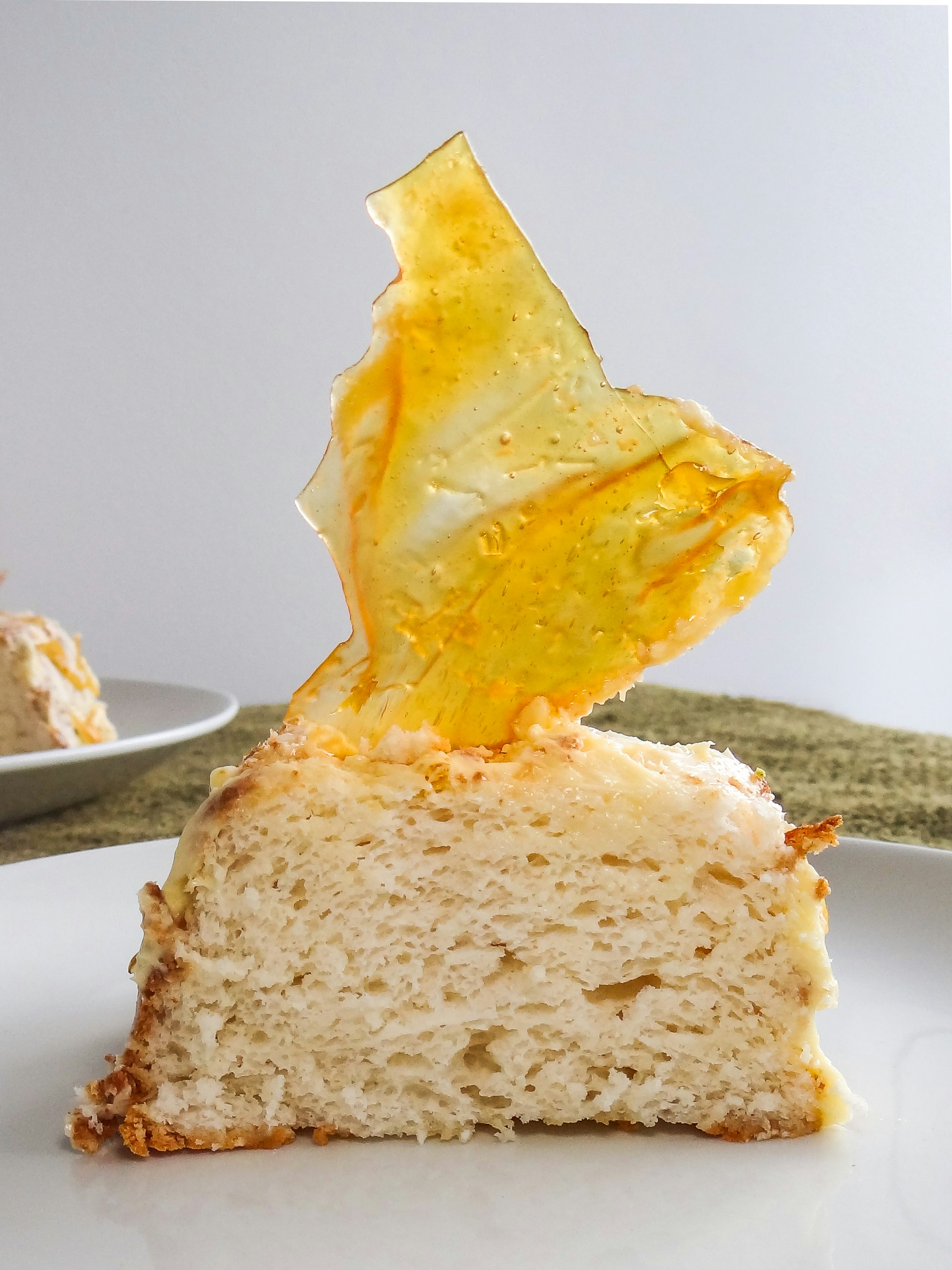 Close-up photograph of a crusty bread slice topped with a brittle parmesan crisp.
