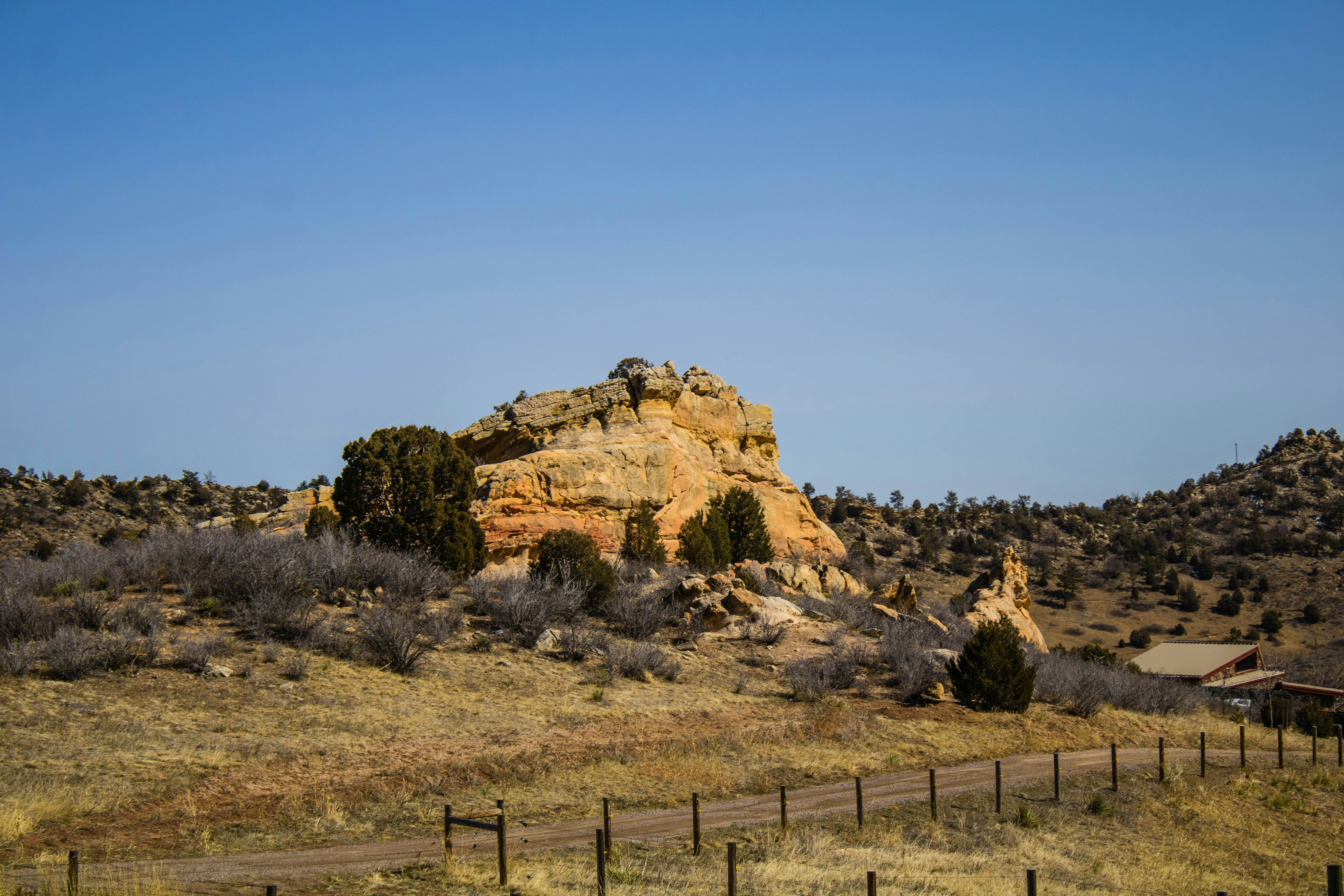Rock formation set against distant mountains under a clear blue sky near Red Rocks Park.