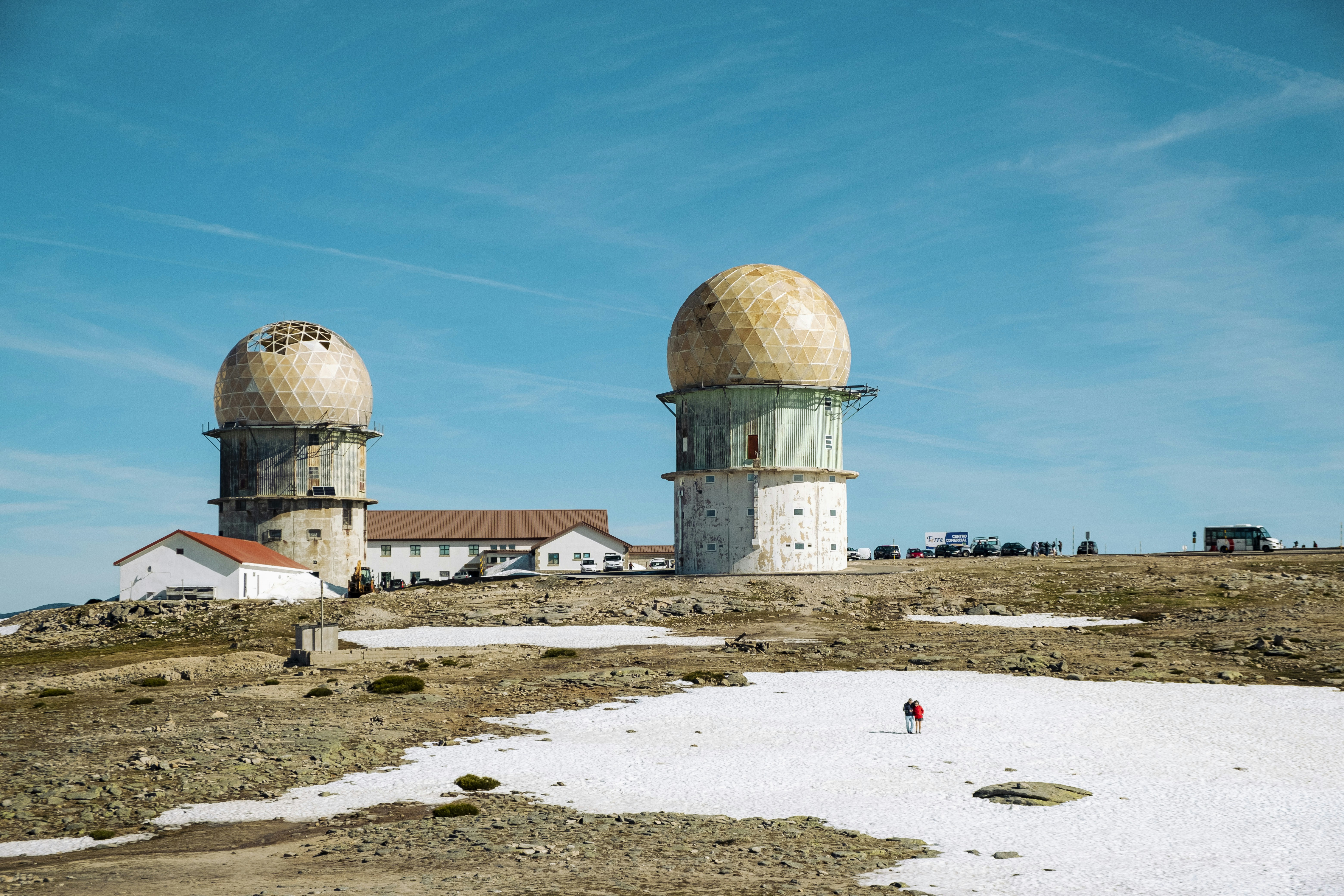 A couple of large telescopes sitting on top of a snow covered field ...