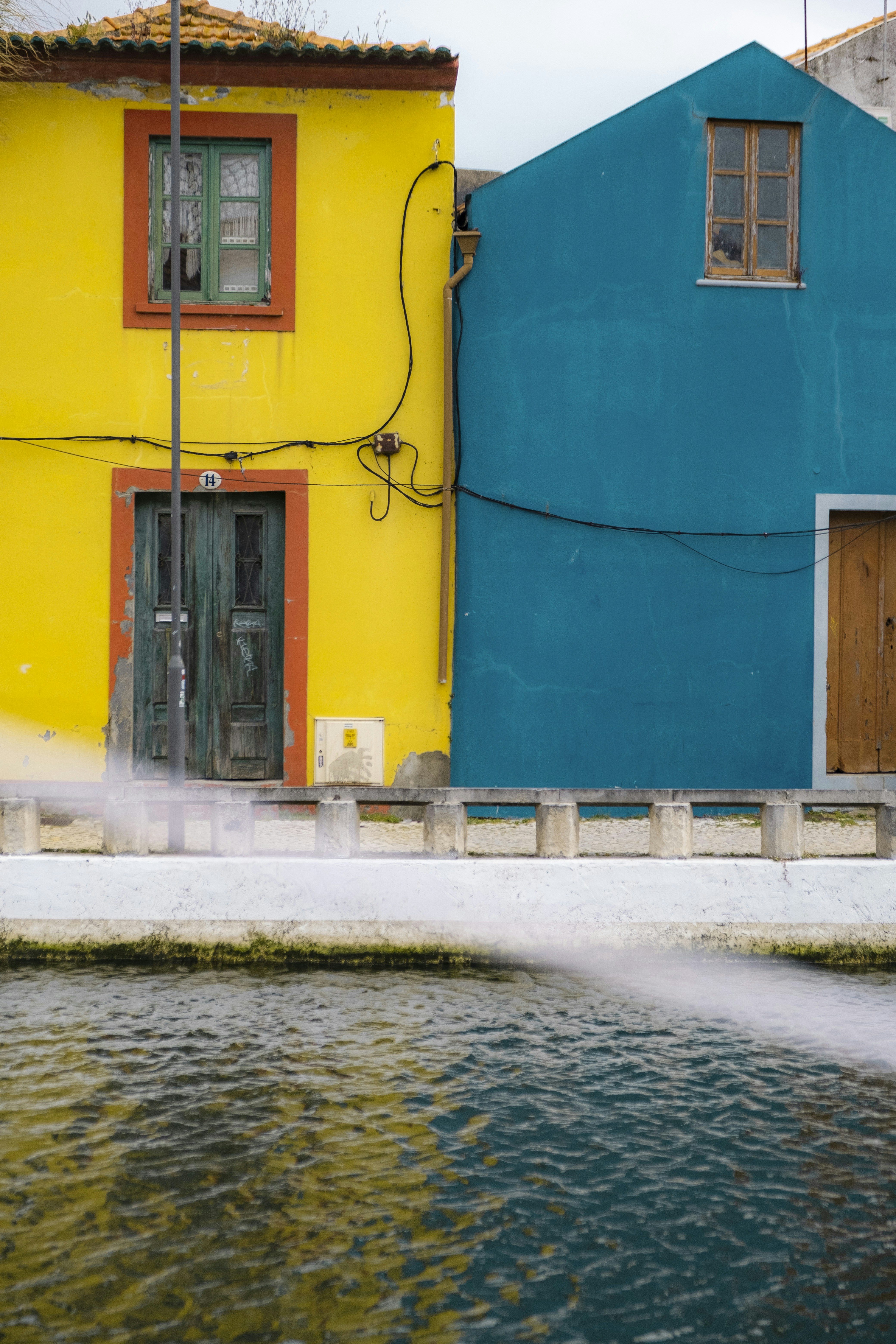 A fire hydrant spewing water in front of a yellow building photo – Free ...