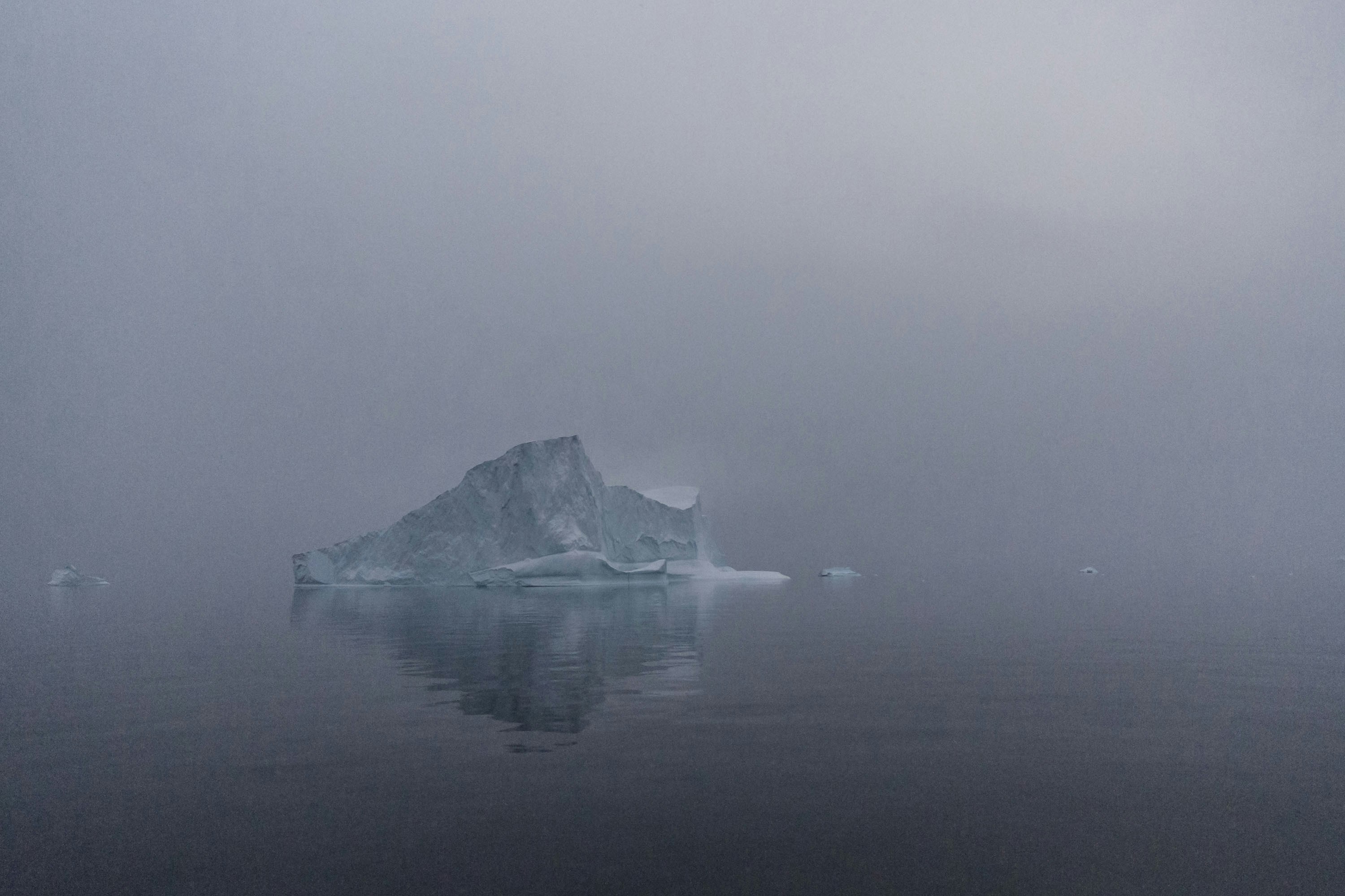 An iceberg in the middle of the ocean on a foggy day photo – Free ...