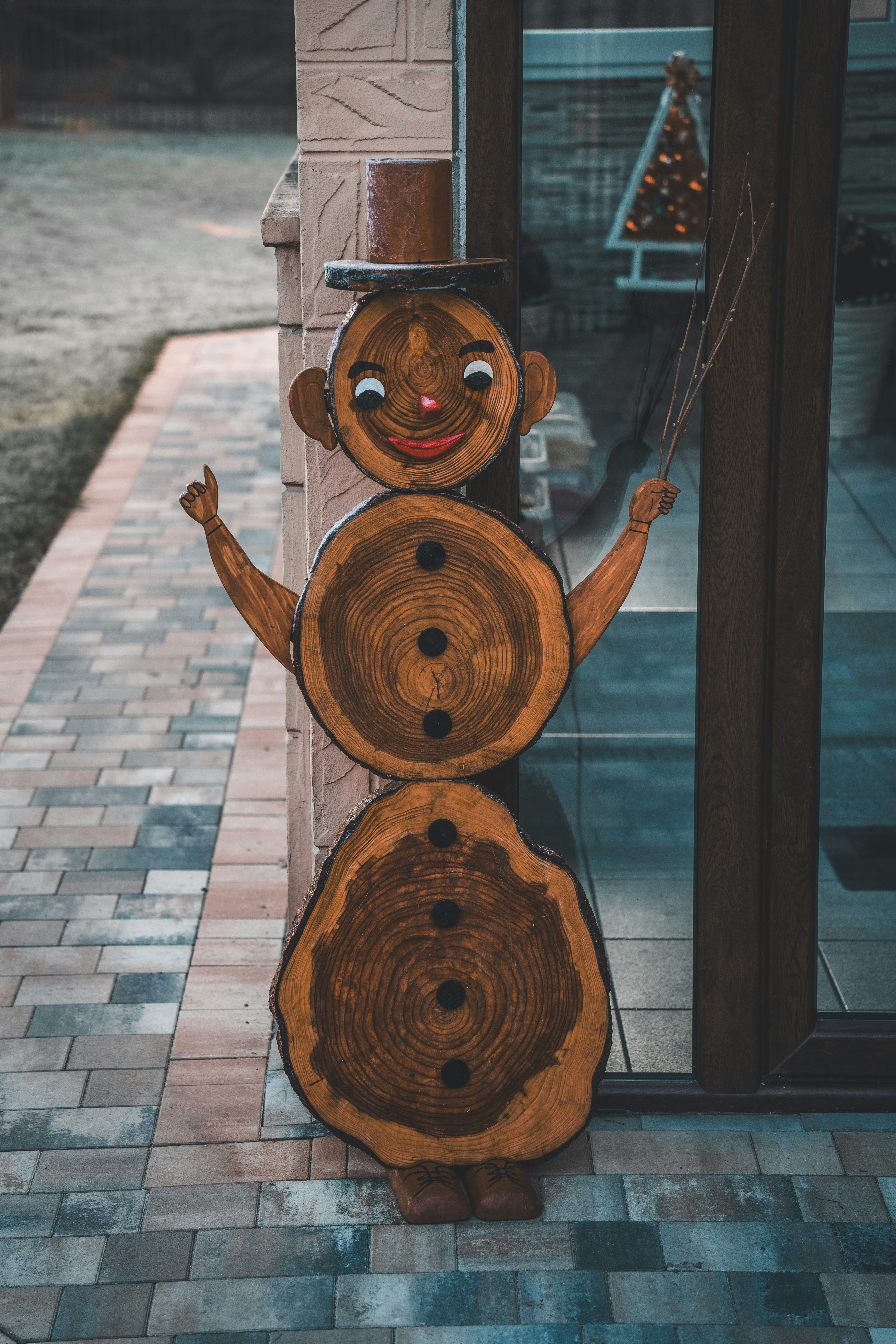 Three-Log Snowman Guards a Storefront Door with a Jovial Smile