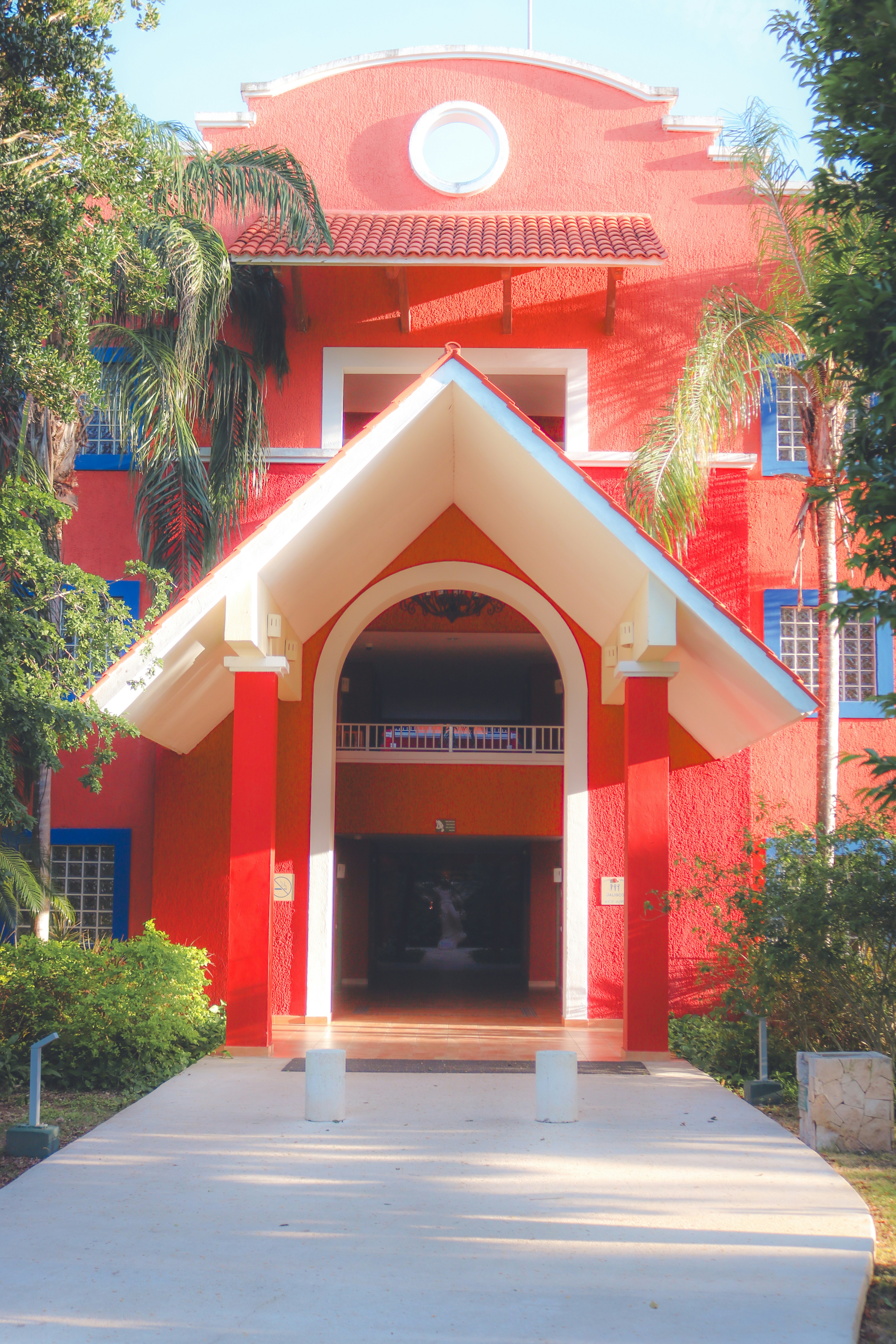 Crimson Campus Arch: Sunlit gateway framed by palms