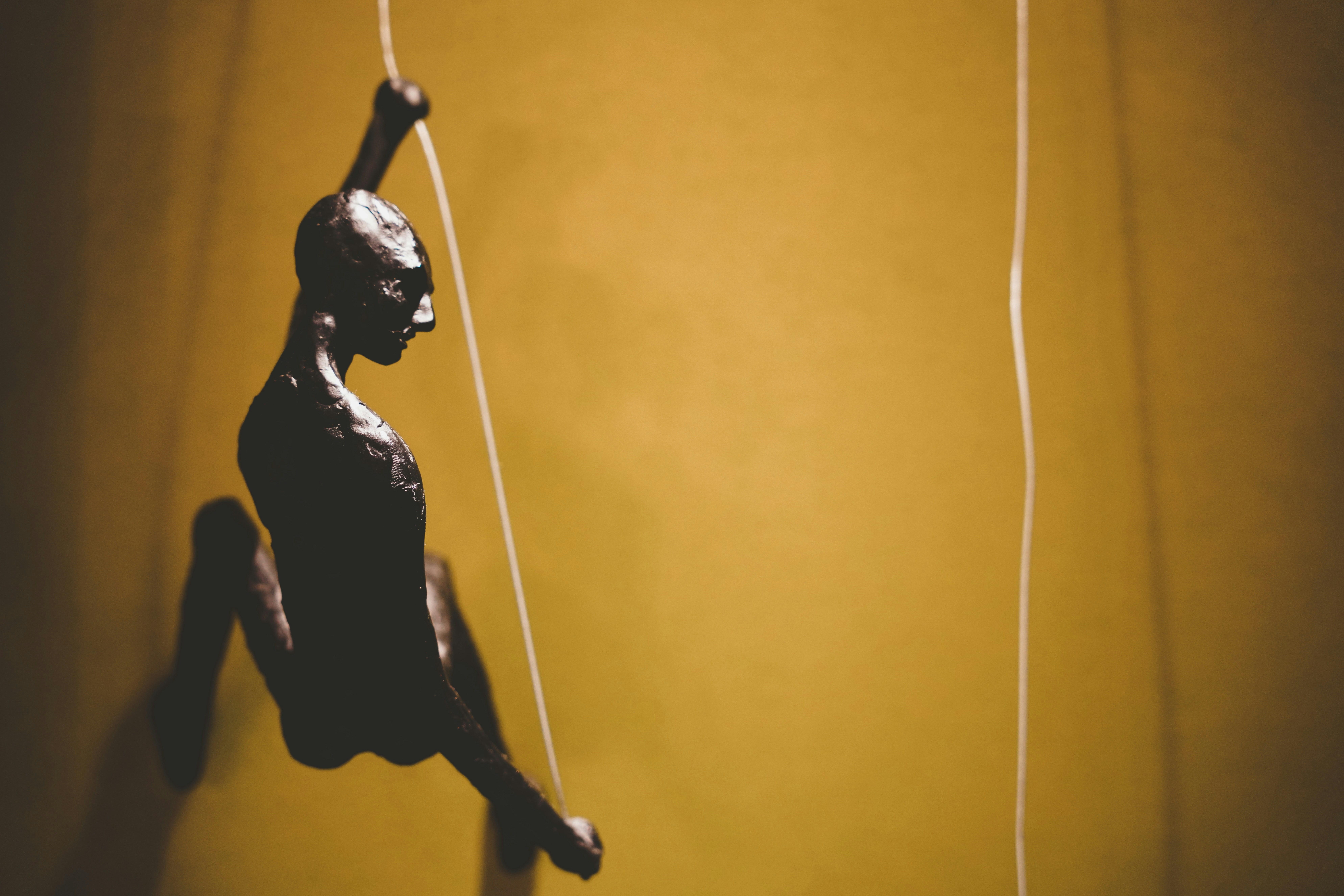 A statue of a man hanging from a string photo – Free Rope Image on Unsplash