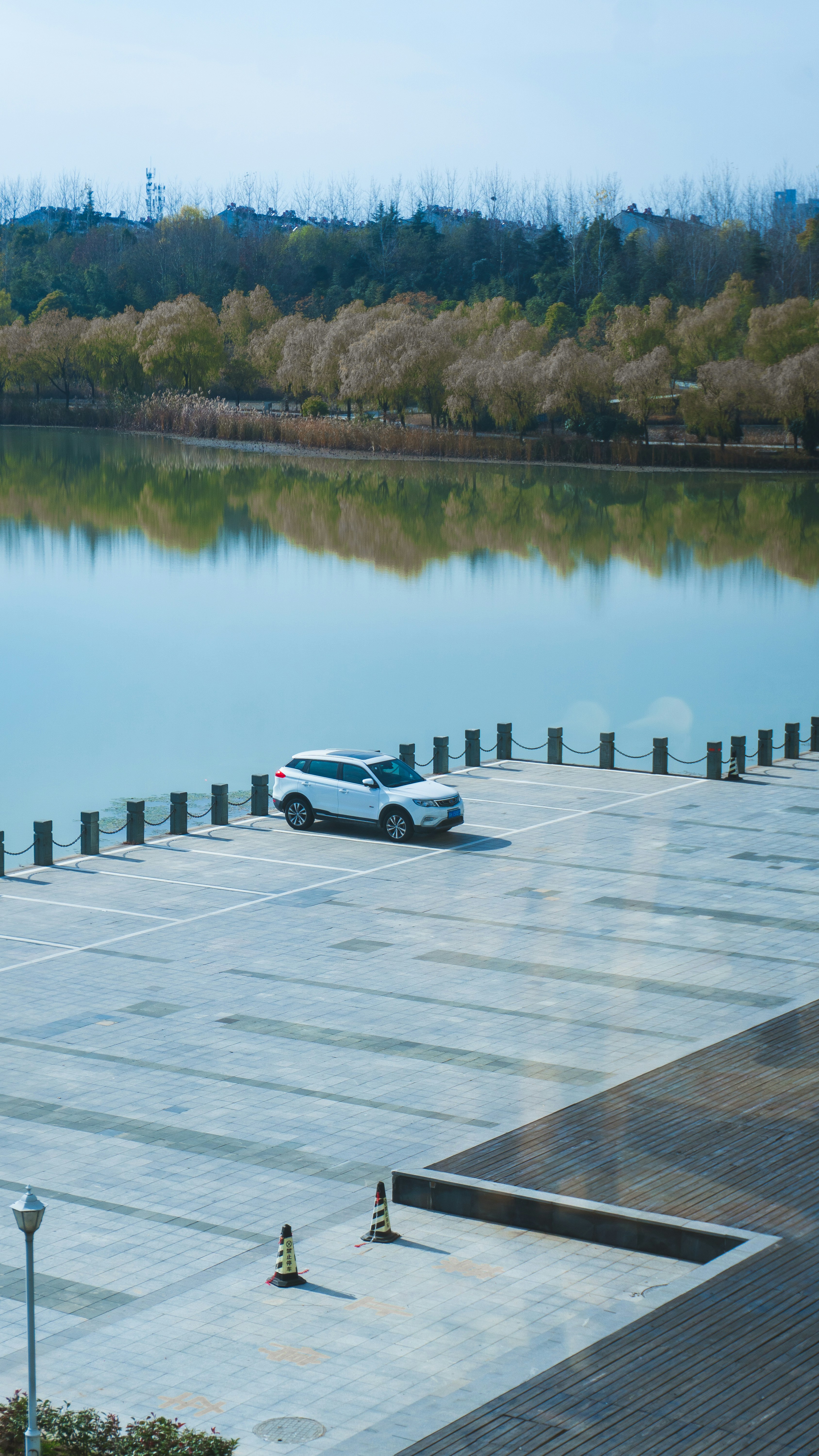 Lakeside Parking Spotlight: White SUV Anchors a Calm Riverside Scene