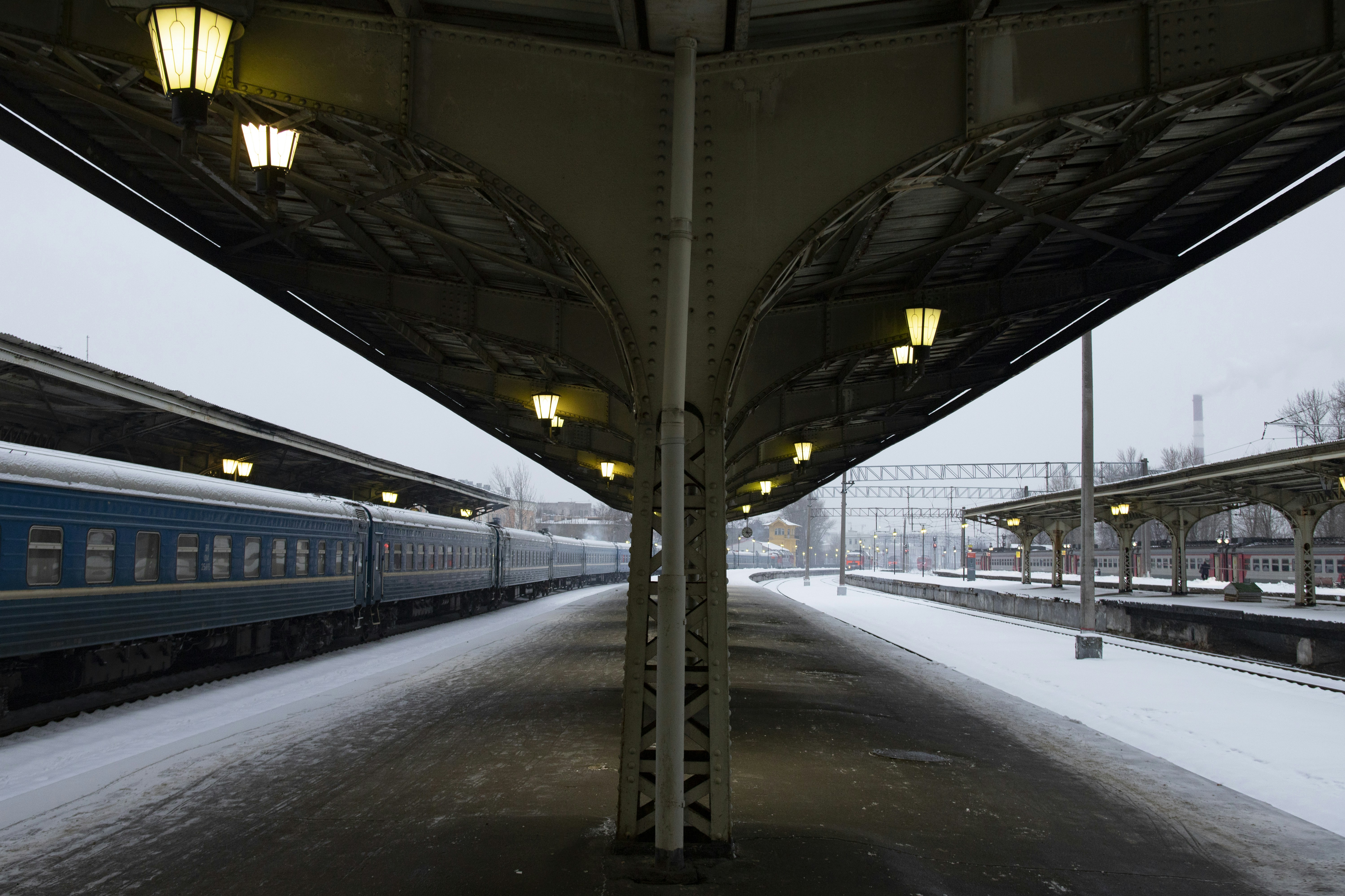 A train traveling through a train station covered in snow photo – Free ...
