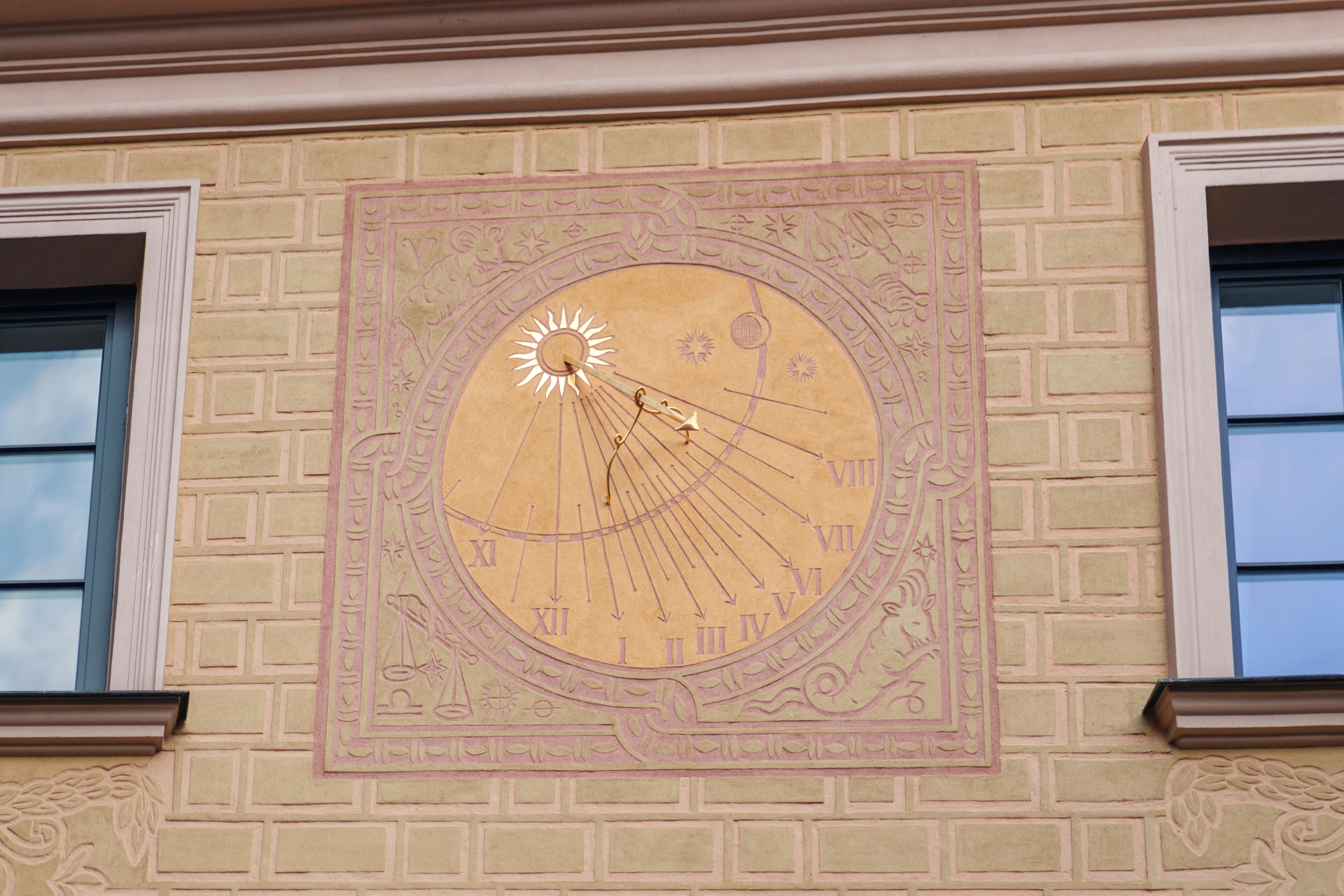 Sunburst Sundial on a Warm Brick Facade