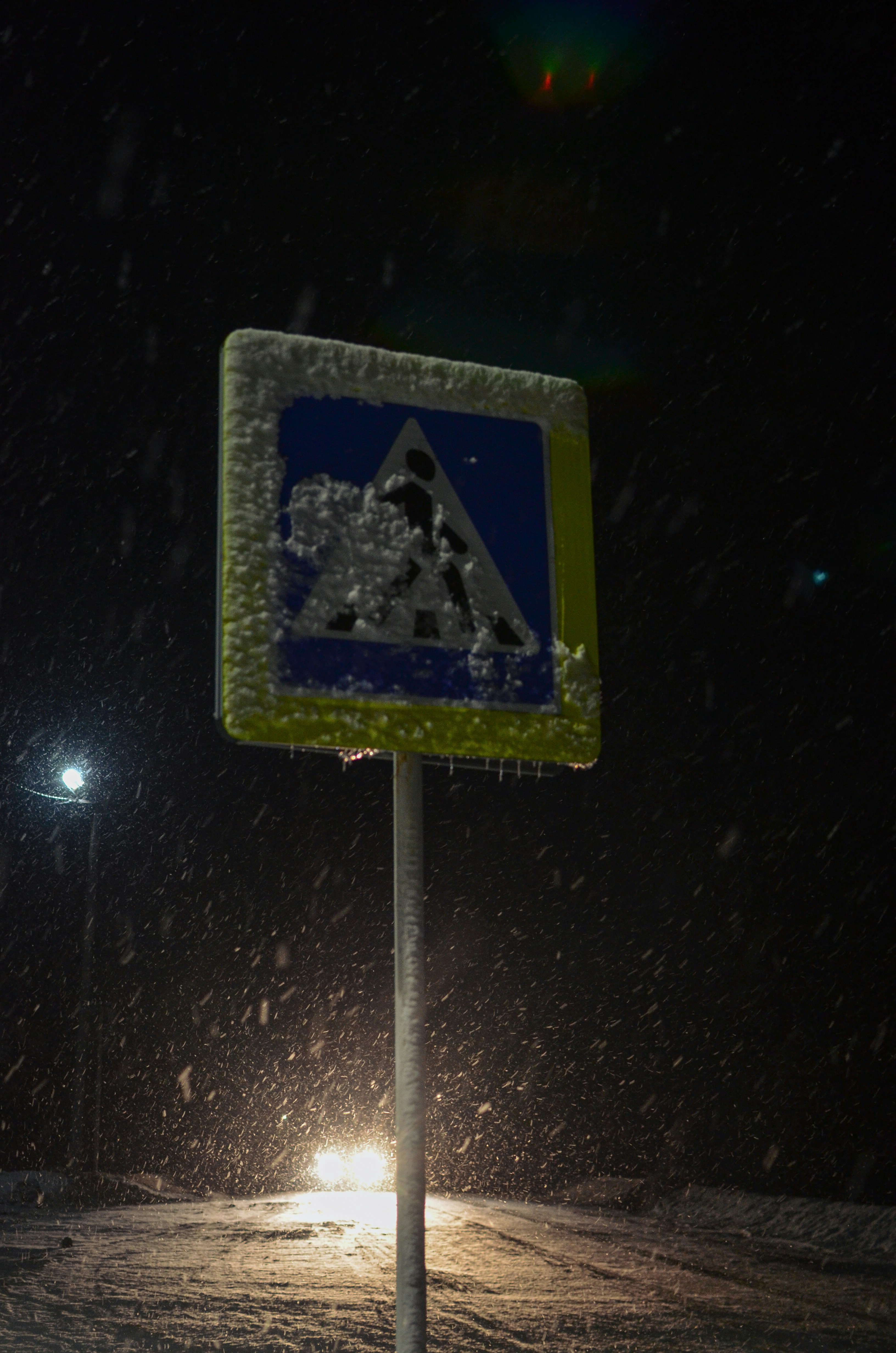 Snow-veiled Crossing Sign Under Night Snowfall