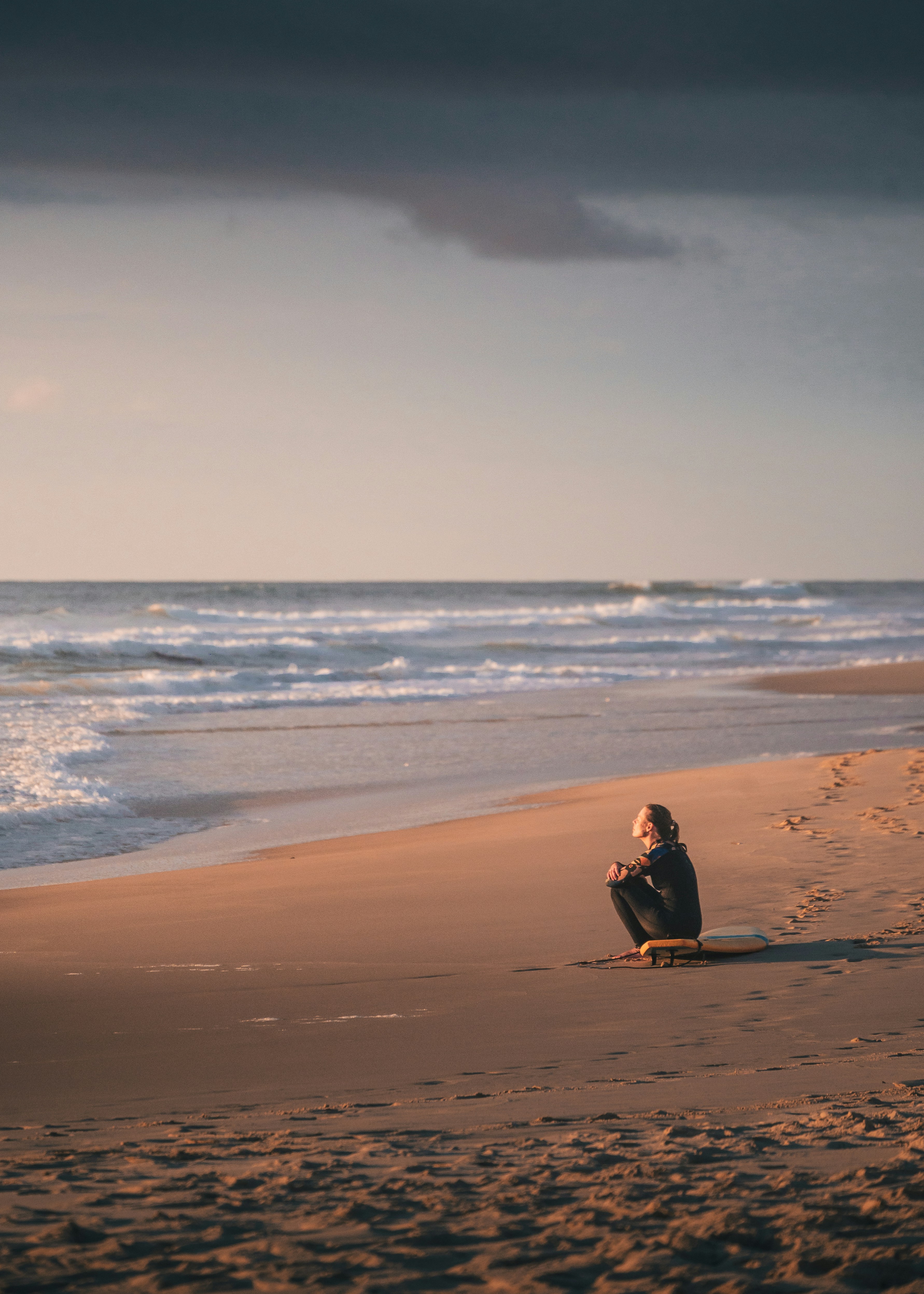 Une personne assise sur une plage à côté de l’océan photo – Image ...
