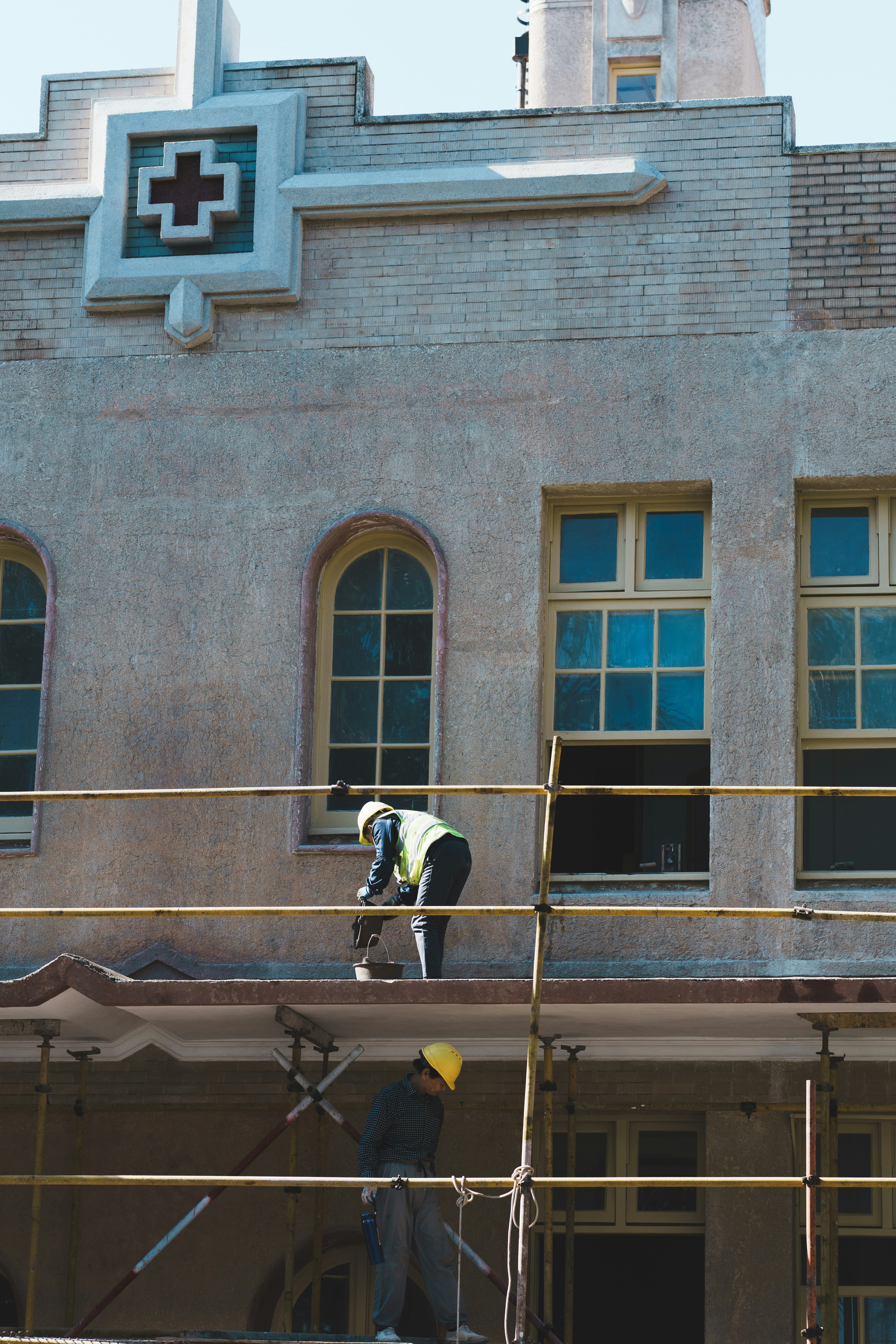 On the Edge: Construction Work Against a Rustic Facade