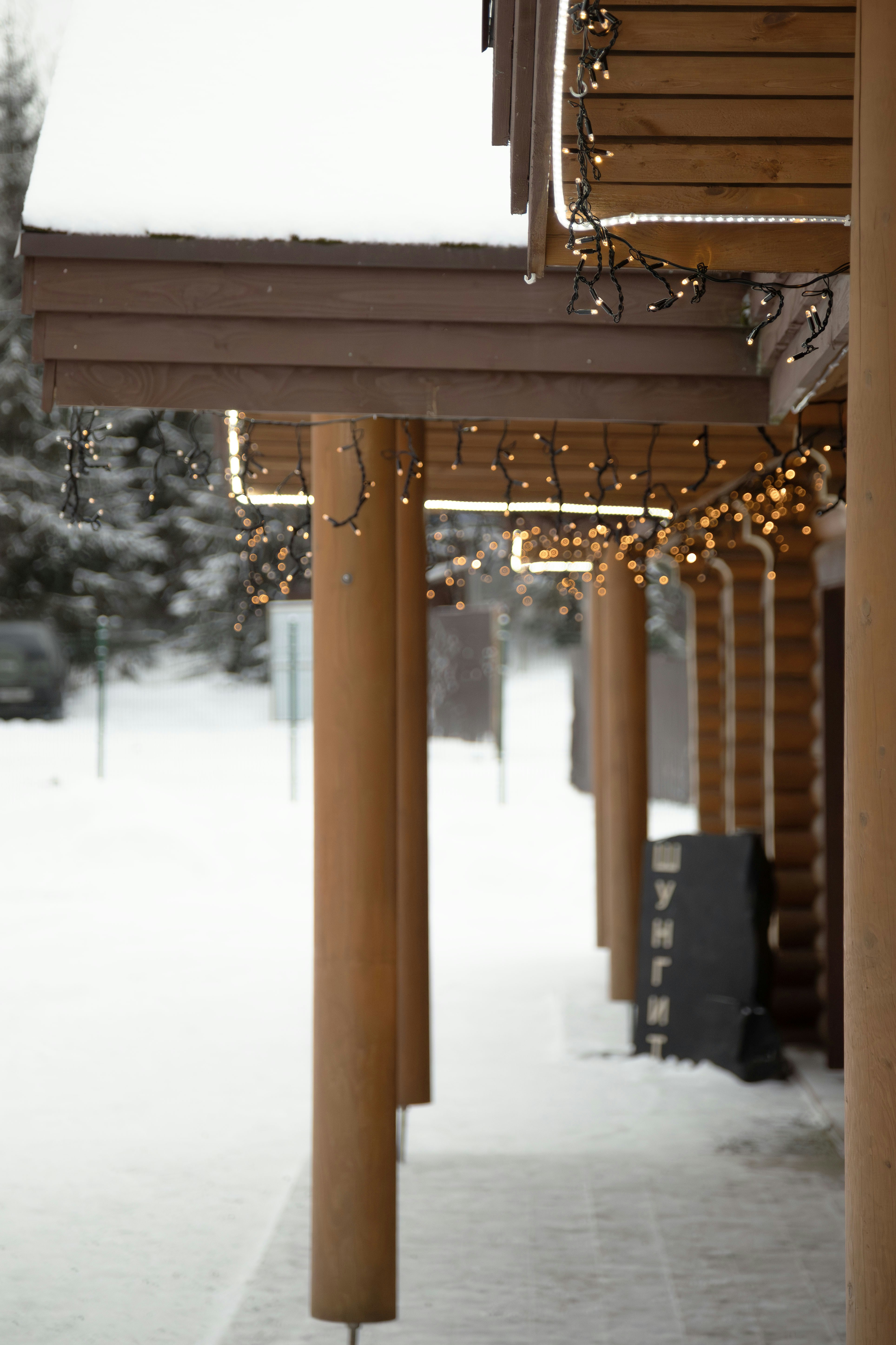 Snowy Veranda Glow: Warm Lights Framing a Wooden Colonnade