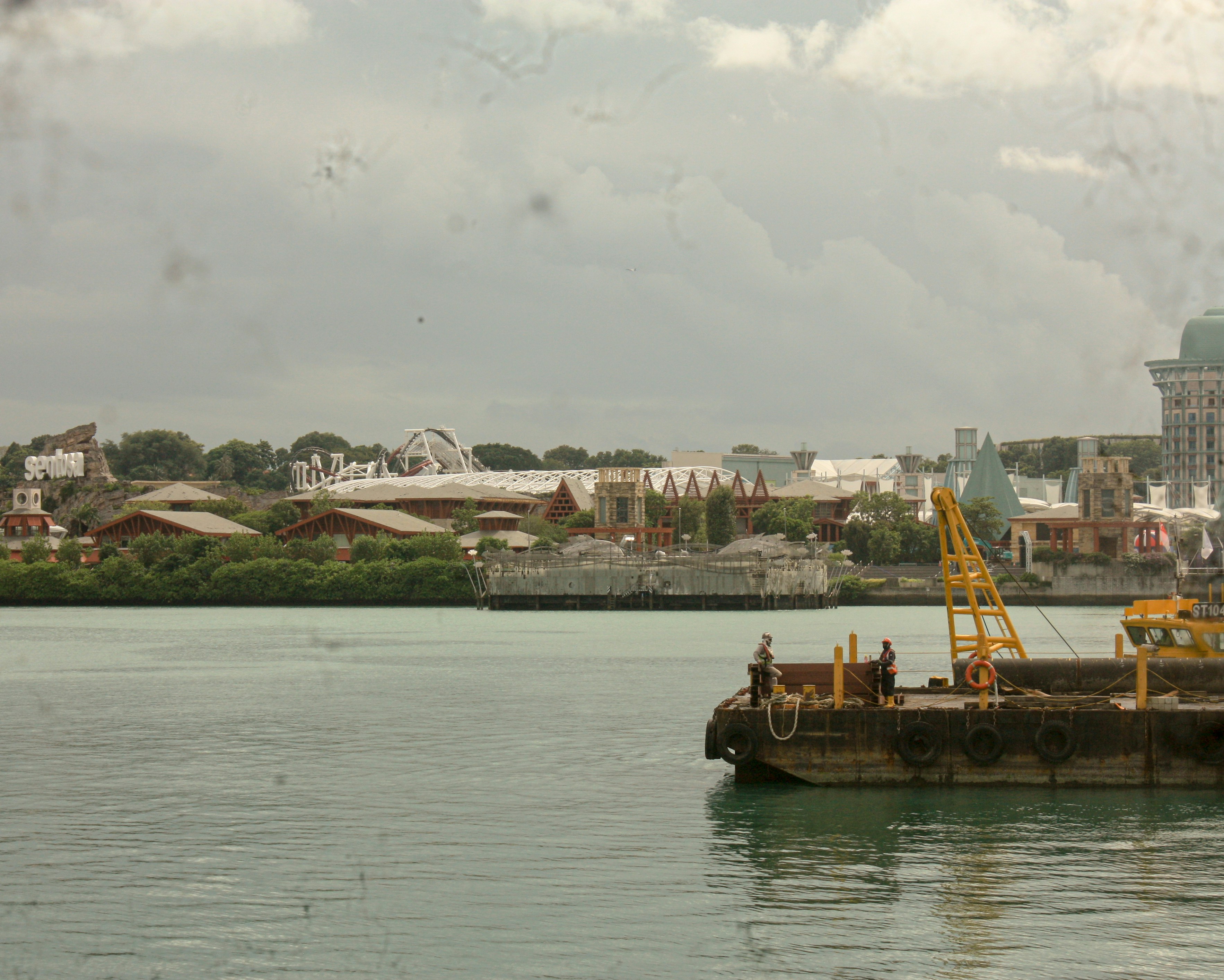Crane Crowned Barge: A Quiet Harbor Scene Framed by Distant City Structures