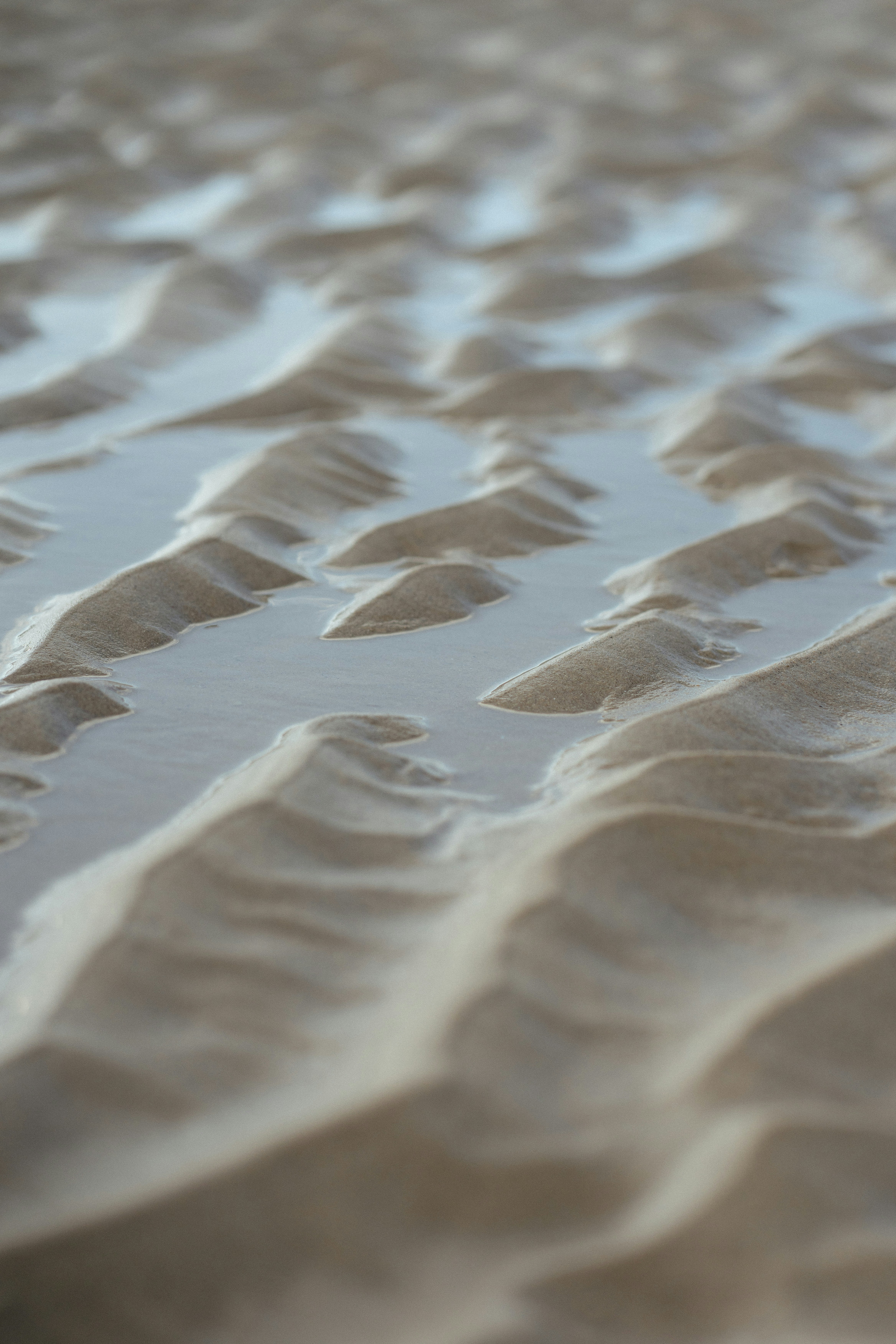 A close up of sand and water on a beach photo – Free Sand Image on Unsplash