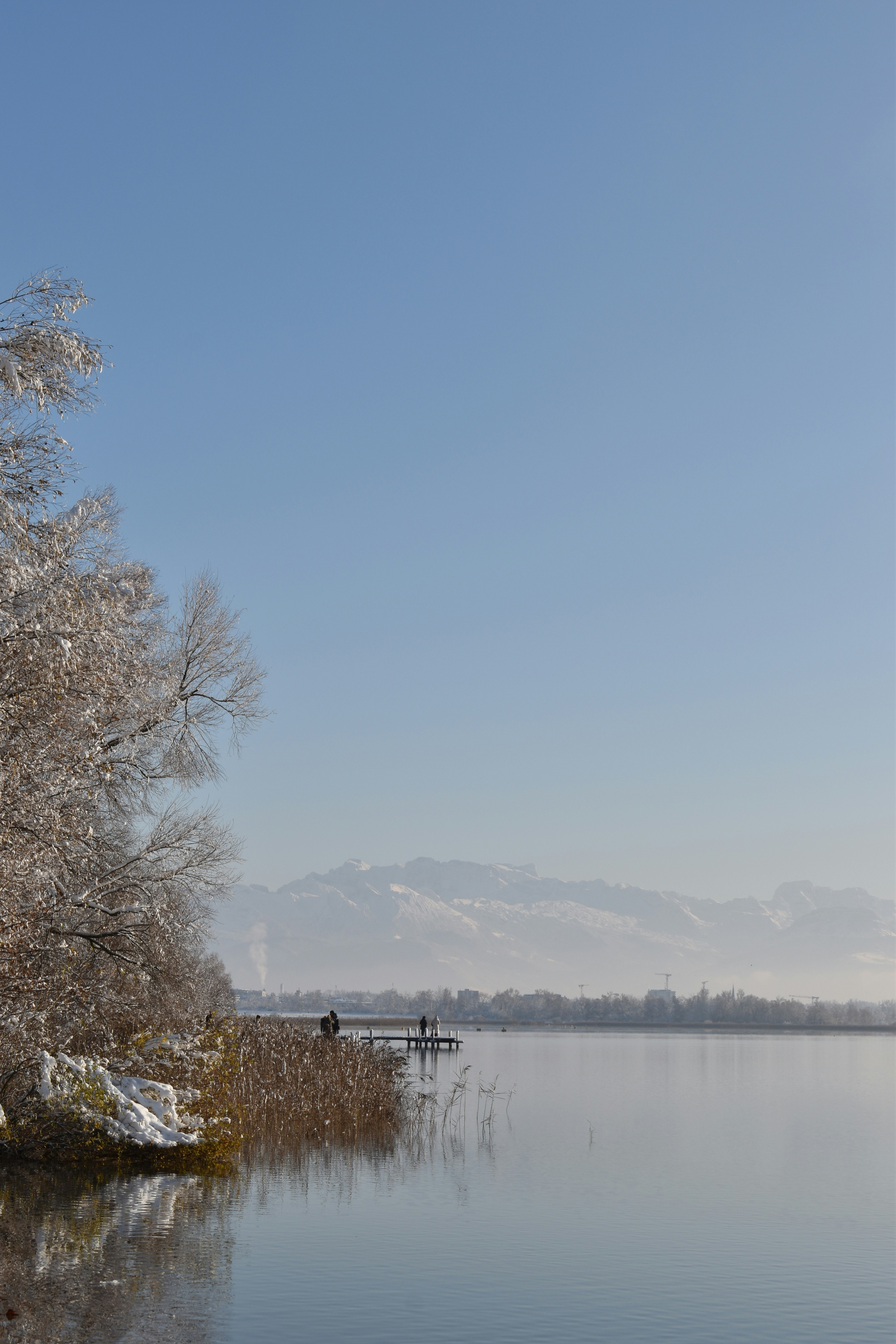 Snow-Kissed Shoreline: A Quiet Pier Framing a Glassy Lake
