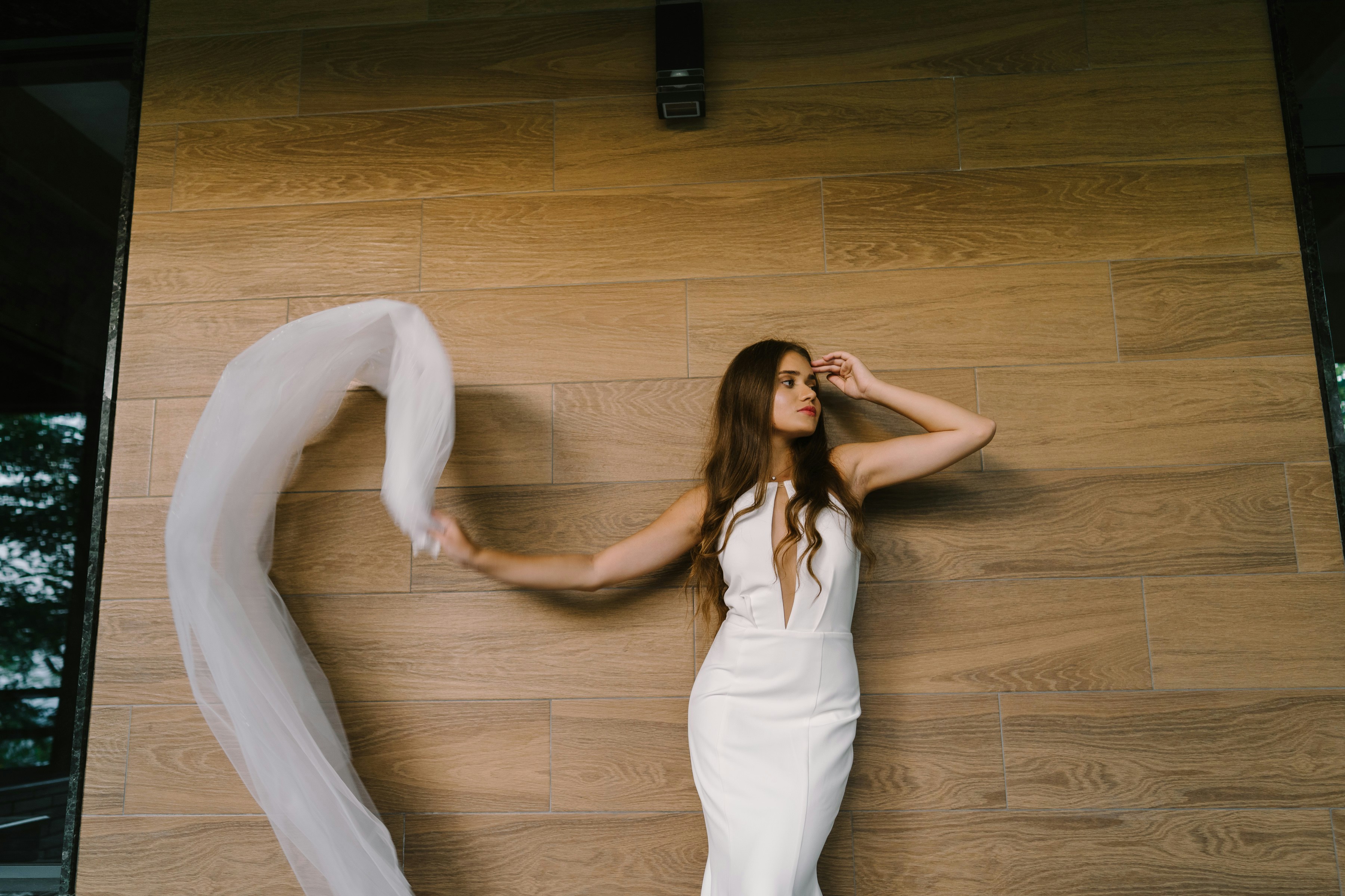 Veil in Motion: Bridal Silhouette Against a Timbered Backdrop