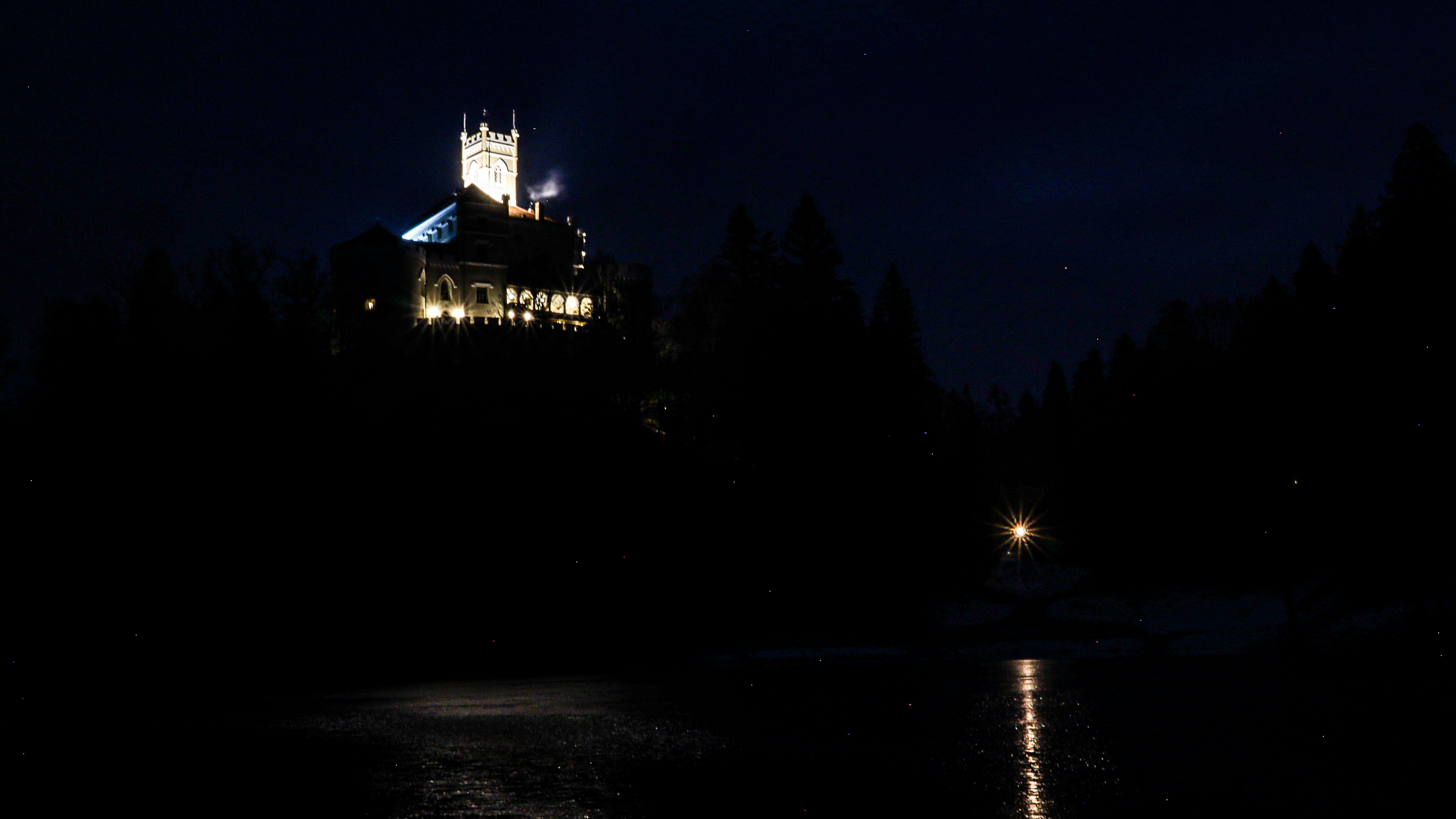 A church lit up at night with trees in the foreground photo – Free ...