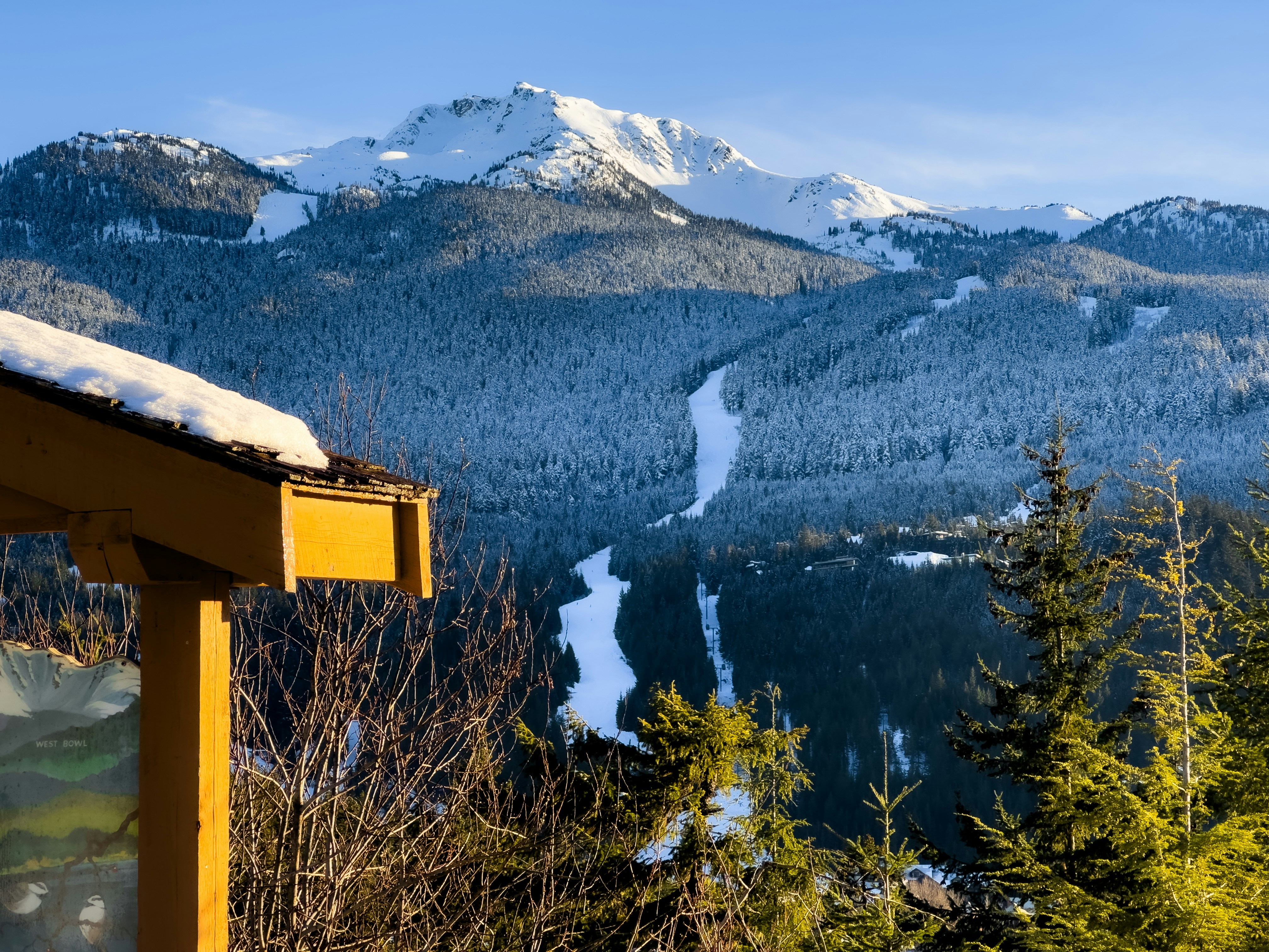 Snow-Dusted Peaks Framed by a Rustic Alpine Shelter in Morning Light