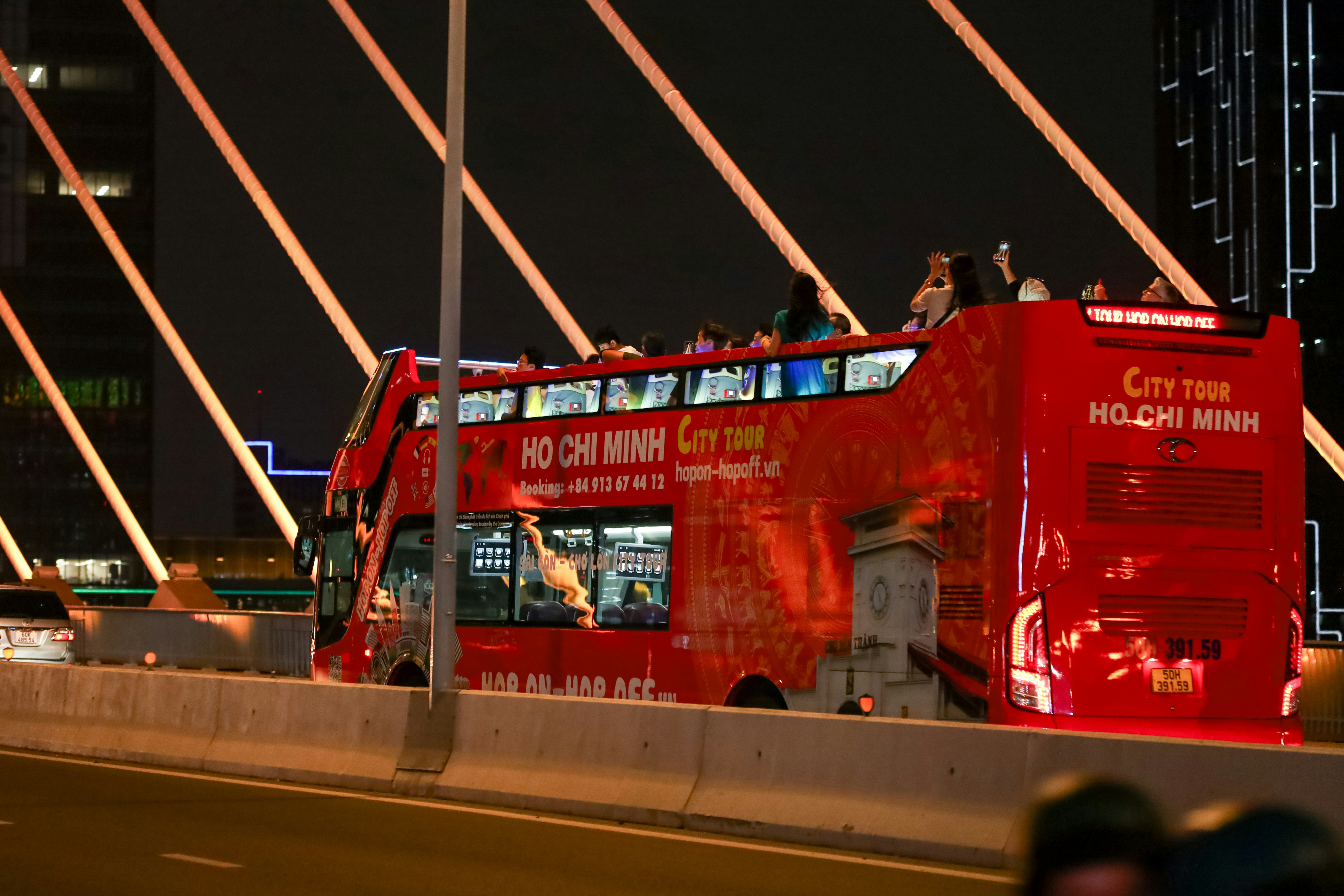 A red double decker bus driving over a bridge photo – Free Ho chi minh ...