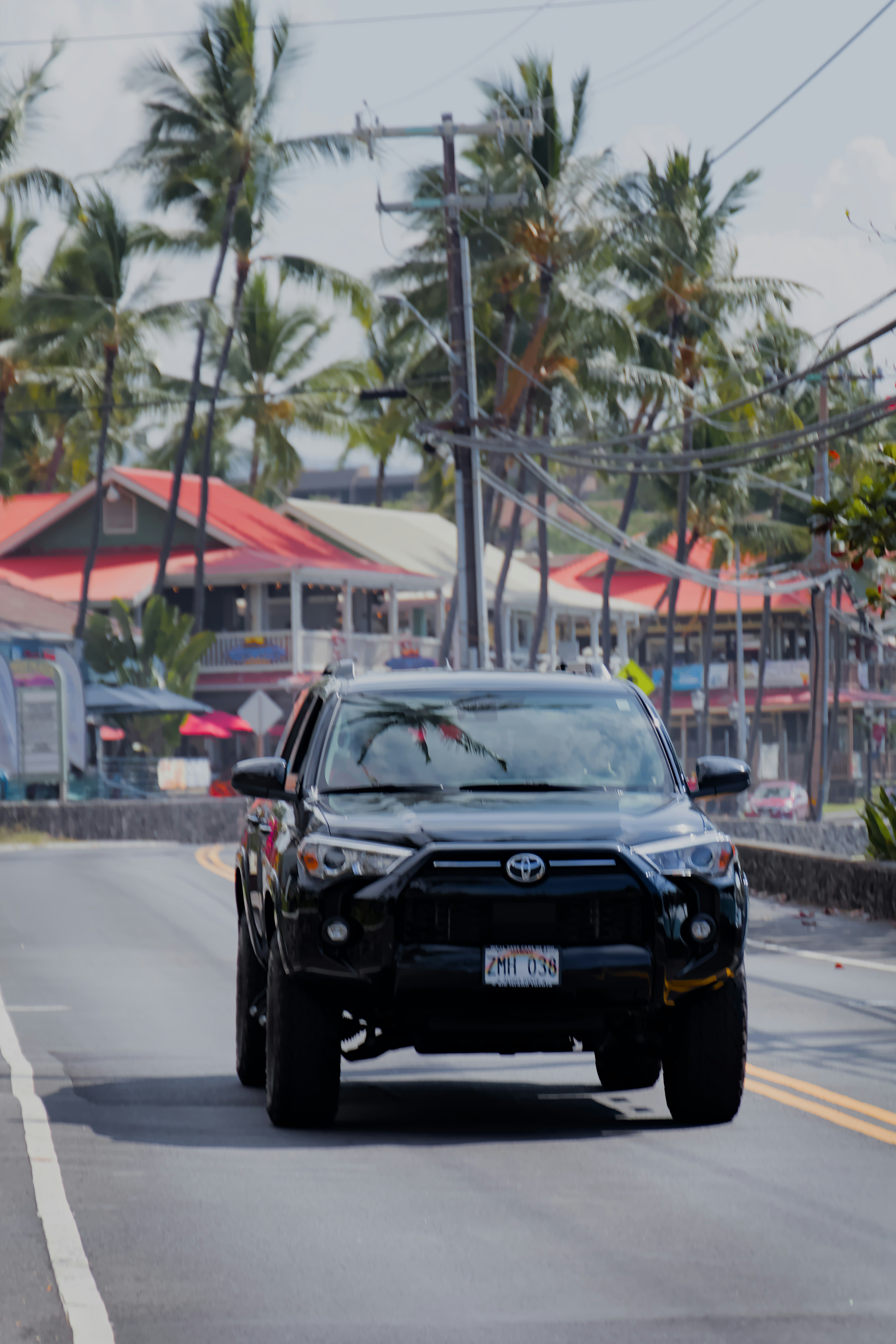 Palm-Fringed Main Street: A Black Pickup Patrols a Sunlit Coastal Town