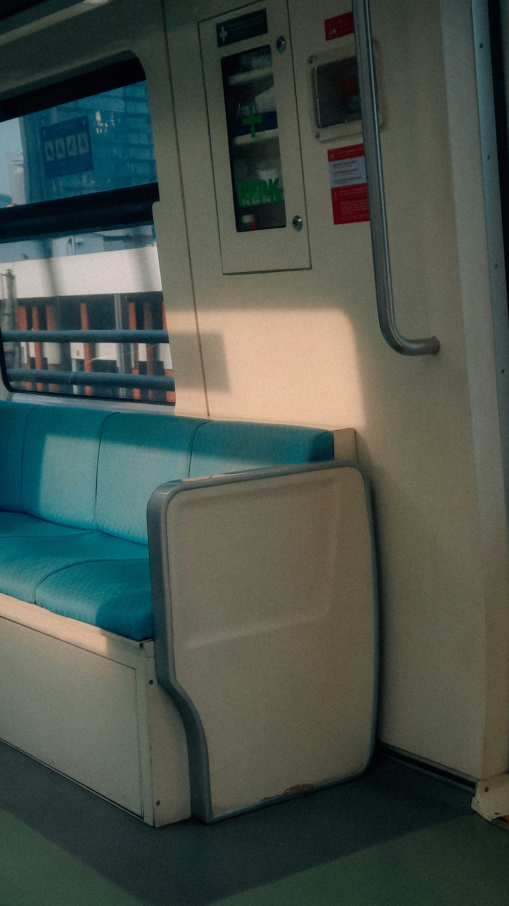 Sunlit Aisle: Teal Seats and Geometry in a Subway Car