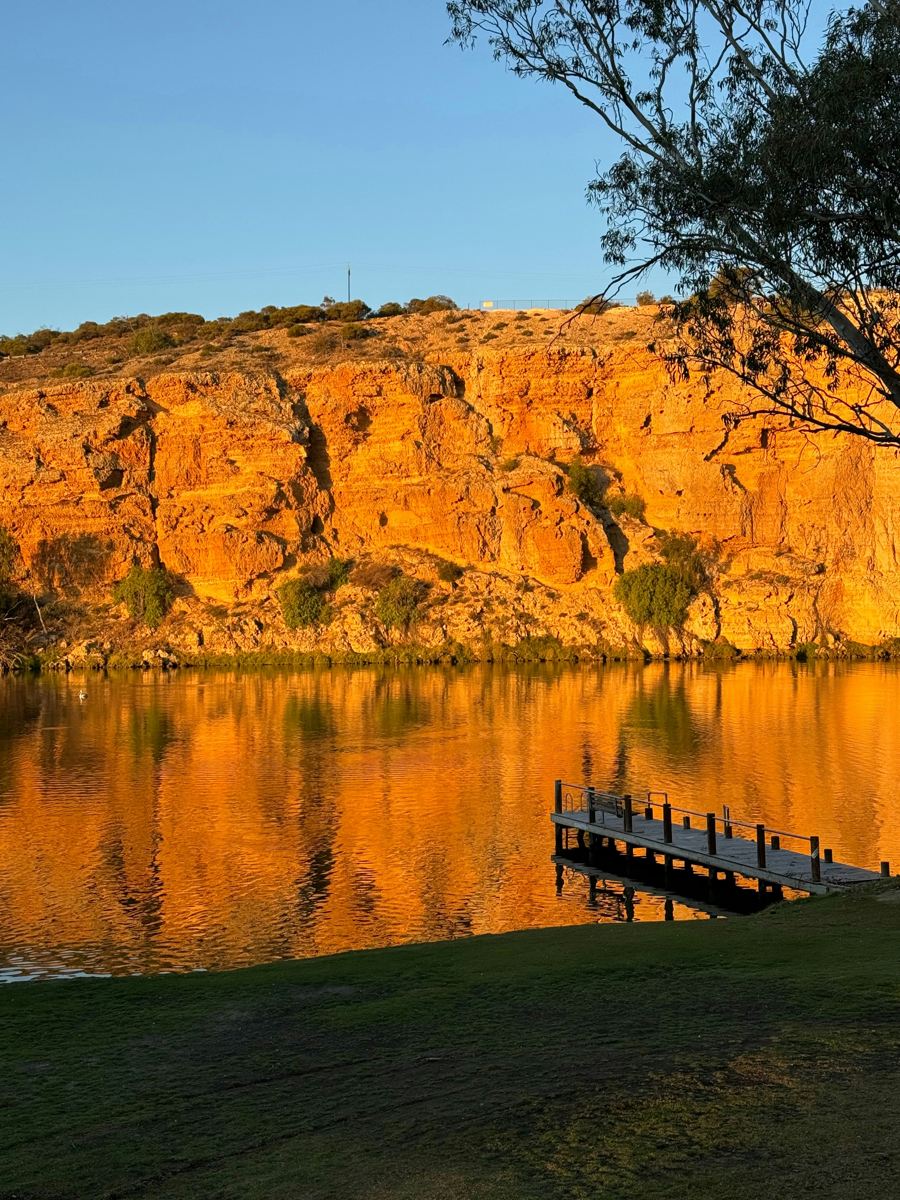 Crimson Cliffs at Dusk: A Quiet Lake Reflects a Wooden Pier