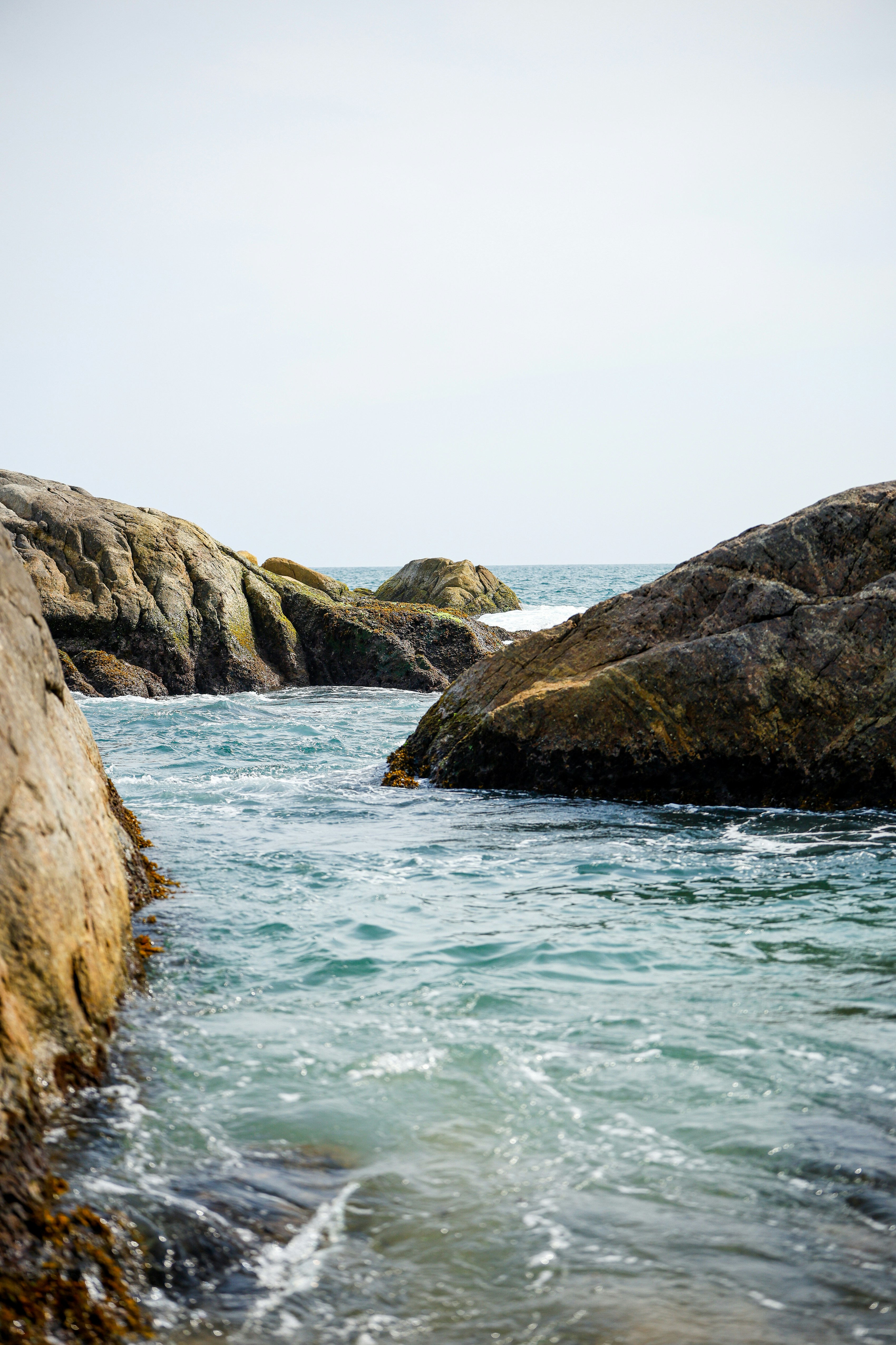 A body of water surrounded by large rocks photo – Free Tamil nadu Image ...