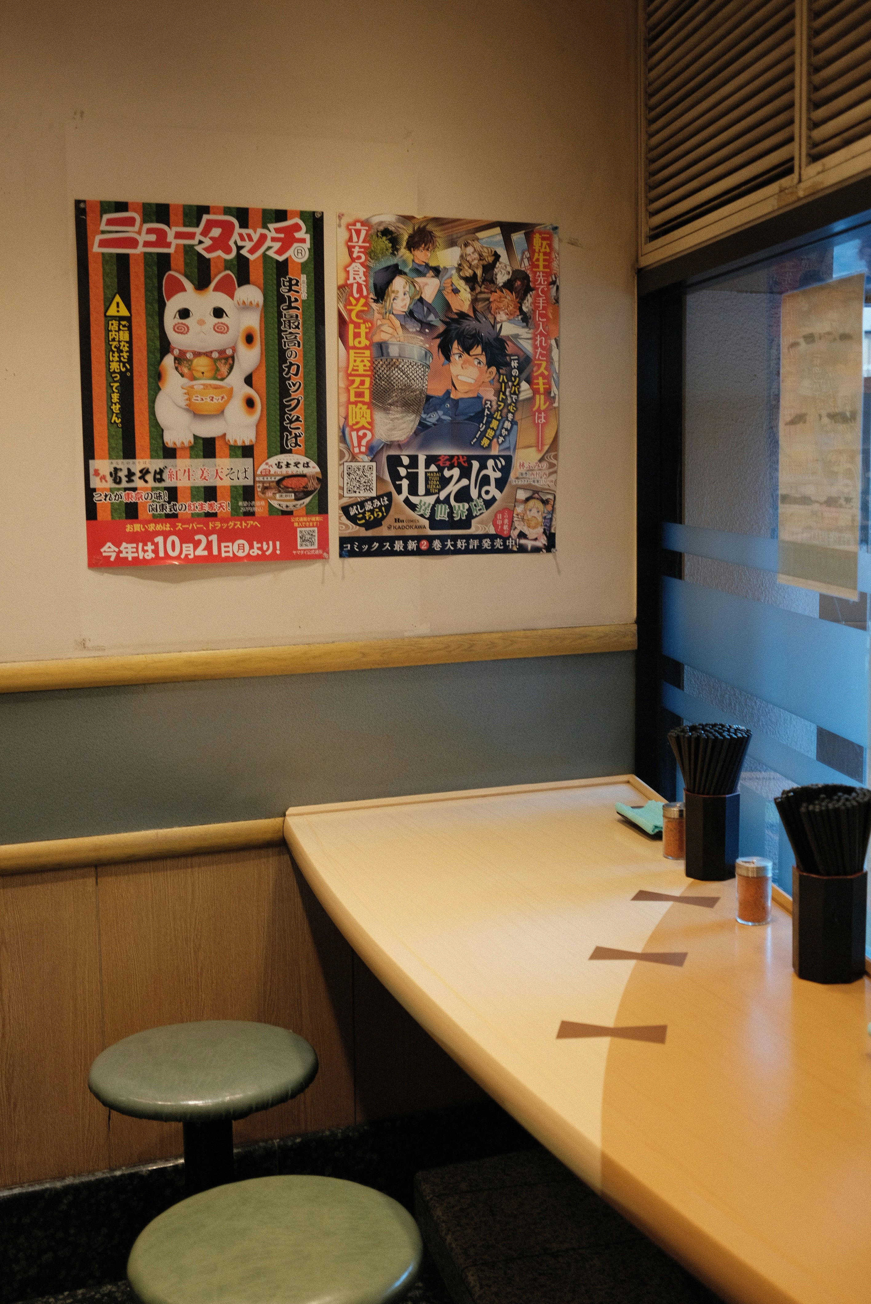 Colorful posters adorn the wall of a cozy eatery, showcasing local cuisine and culture. The inviting table setting hints at a warm dining experience.