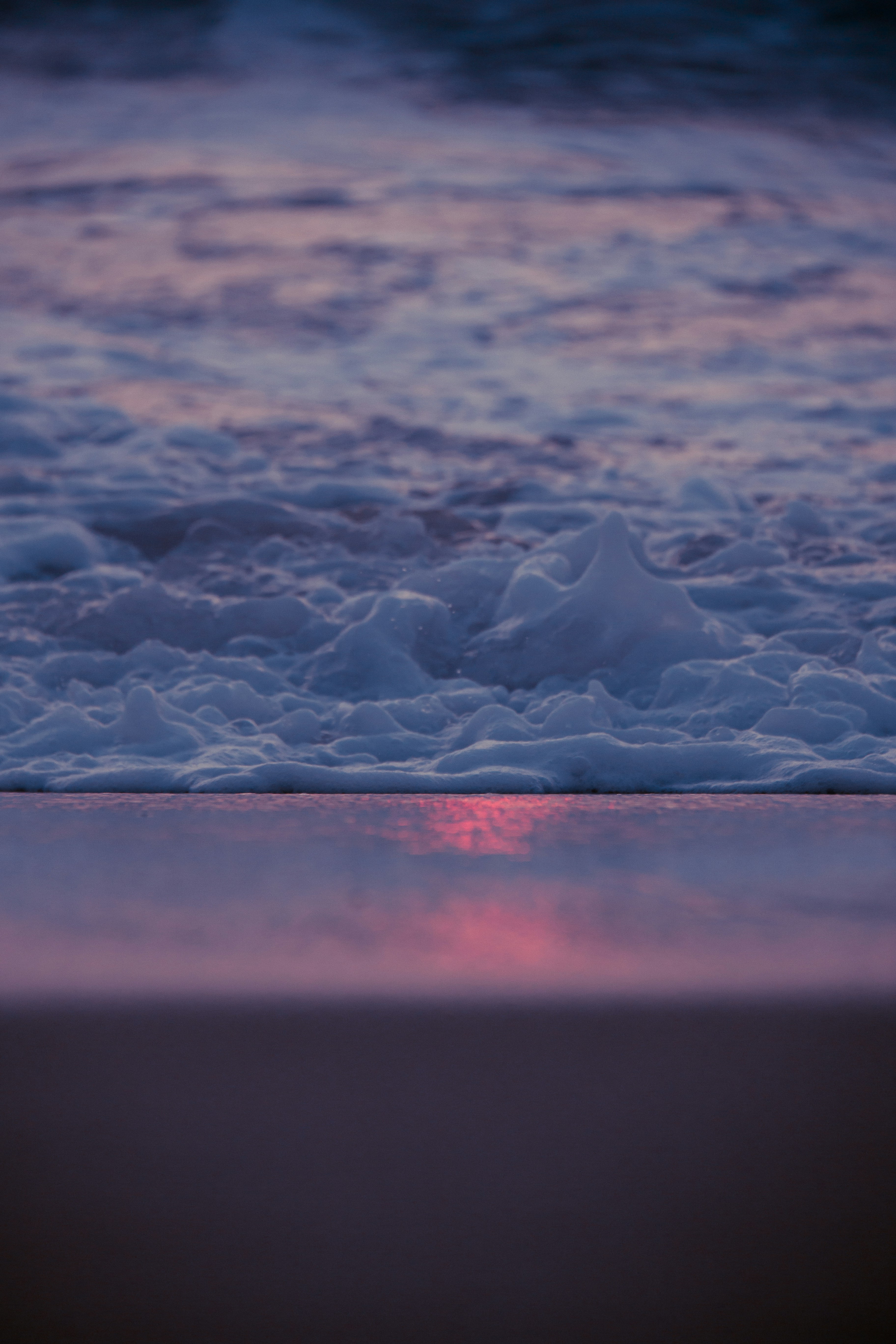 Edge of Twilight: Pink Reflection on Foamy Shore