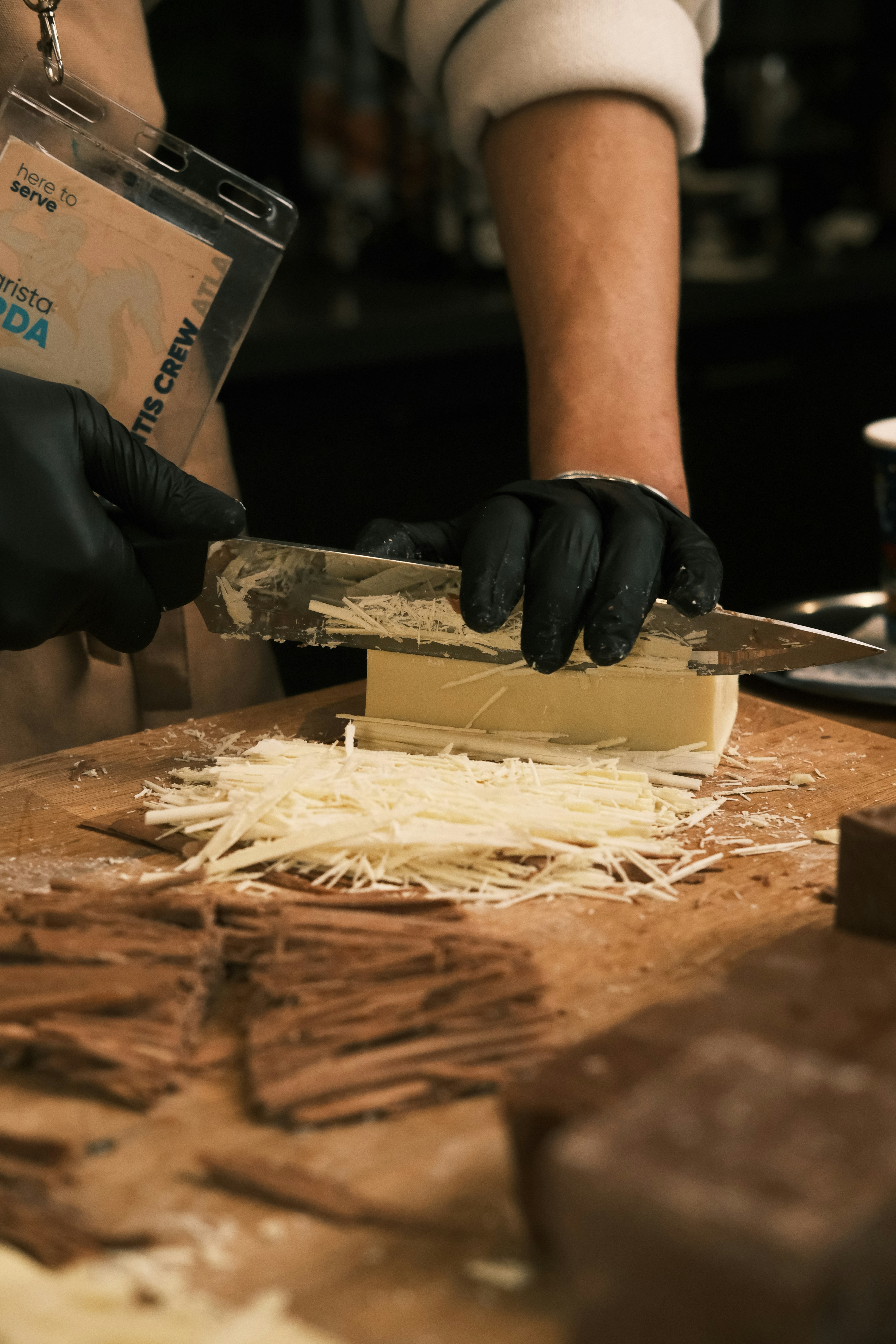 Shavings in Quiet Focus: Precision Cheese Cutting on a Wooden Board