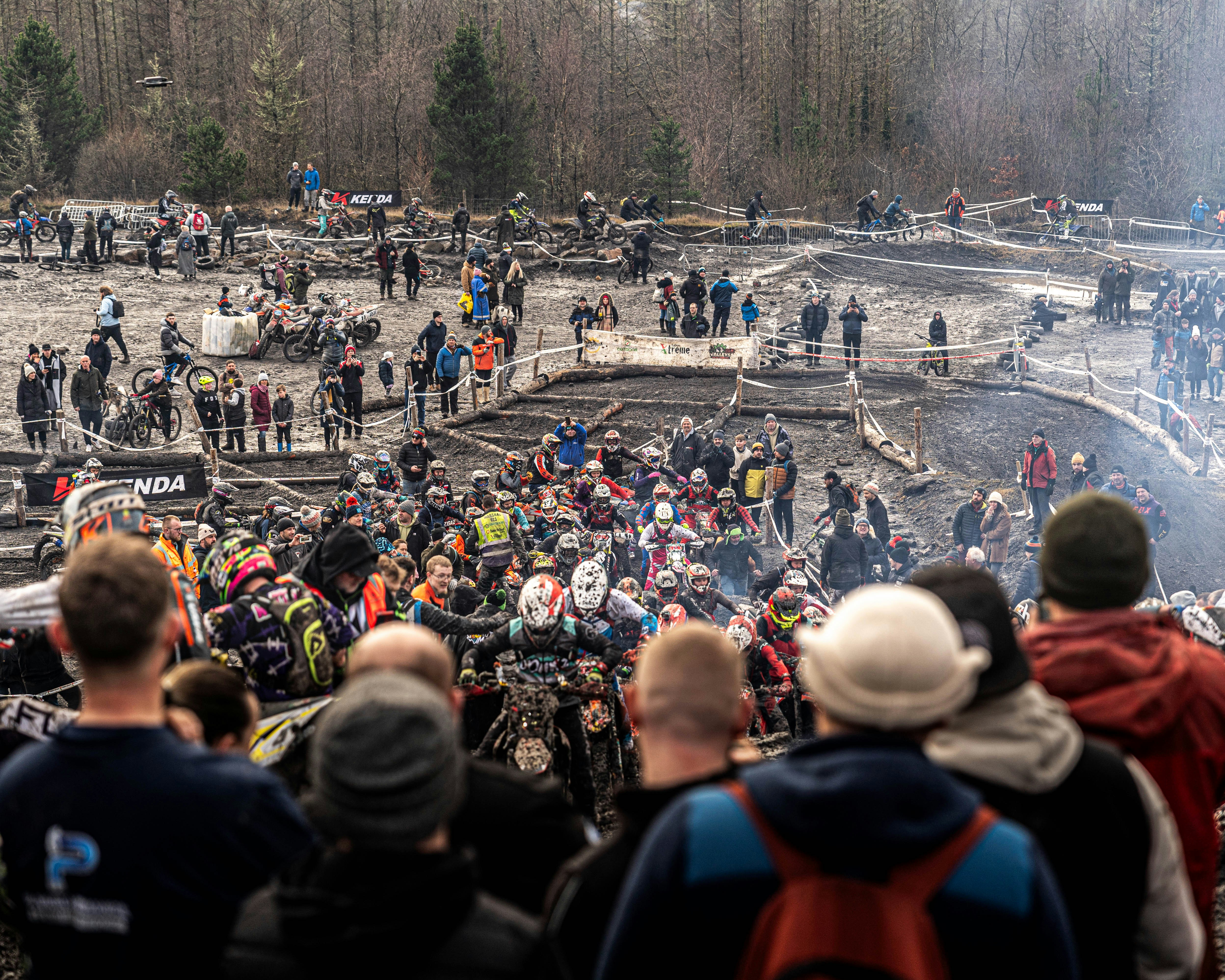A crowd of people standing around a fire pit photo – Free Human Image ...