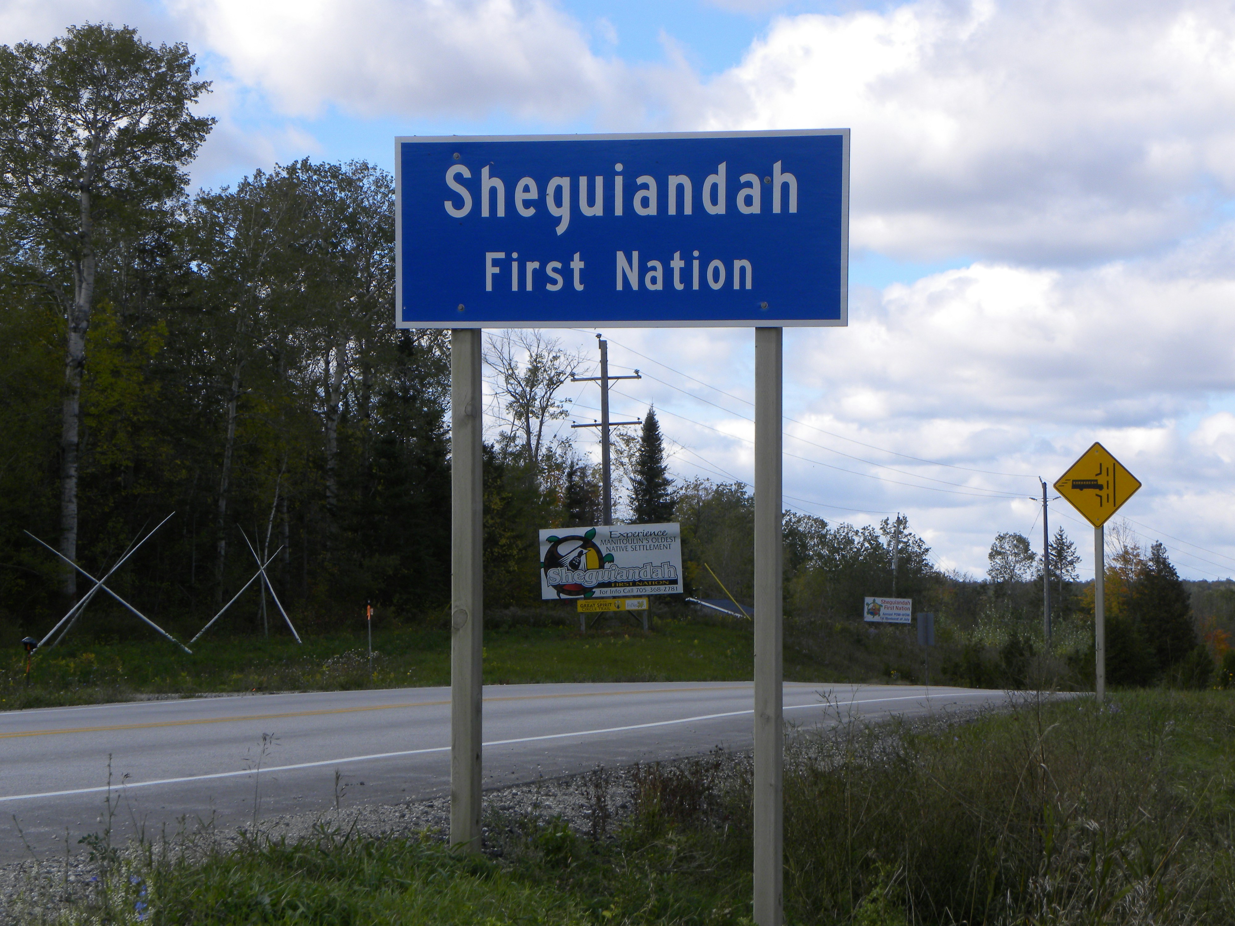 Blue Welcome Sign for Sheguindah First Nation Anchors a Quiet Highway Scene