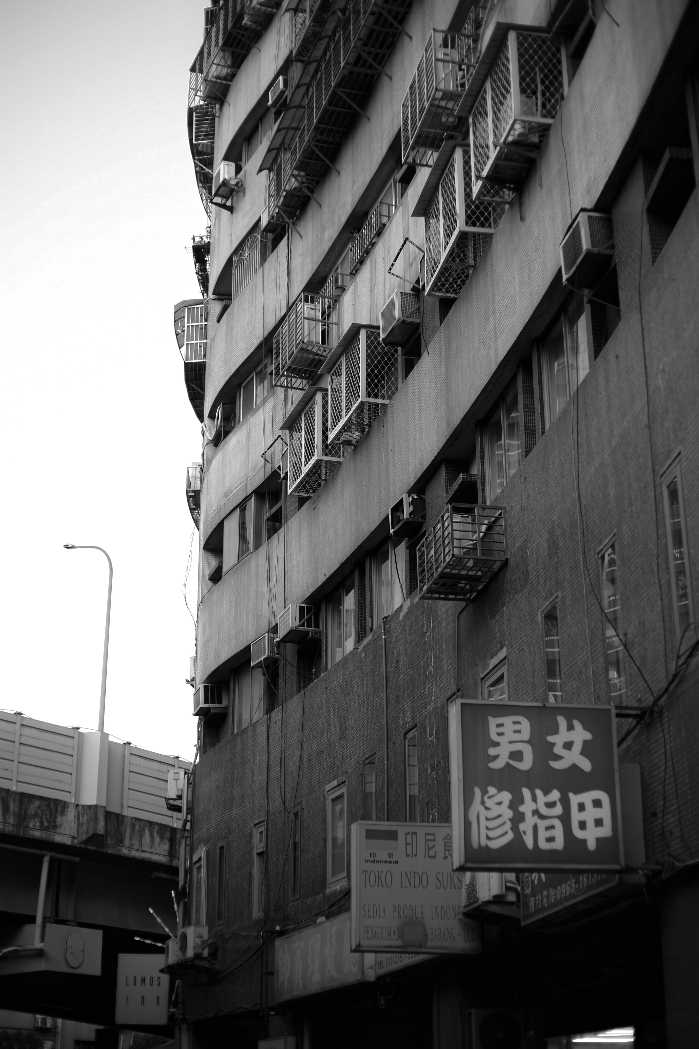 Vertical Cityscape: Balconies Cling to a Curved Concrete Facade