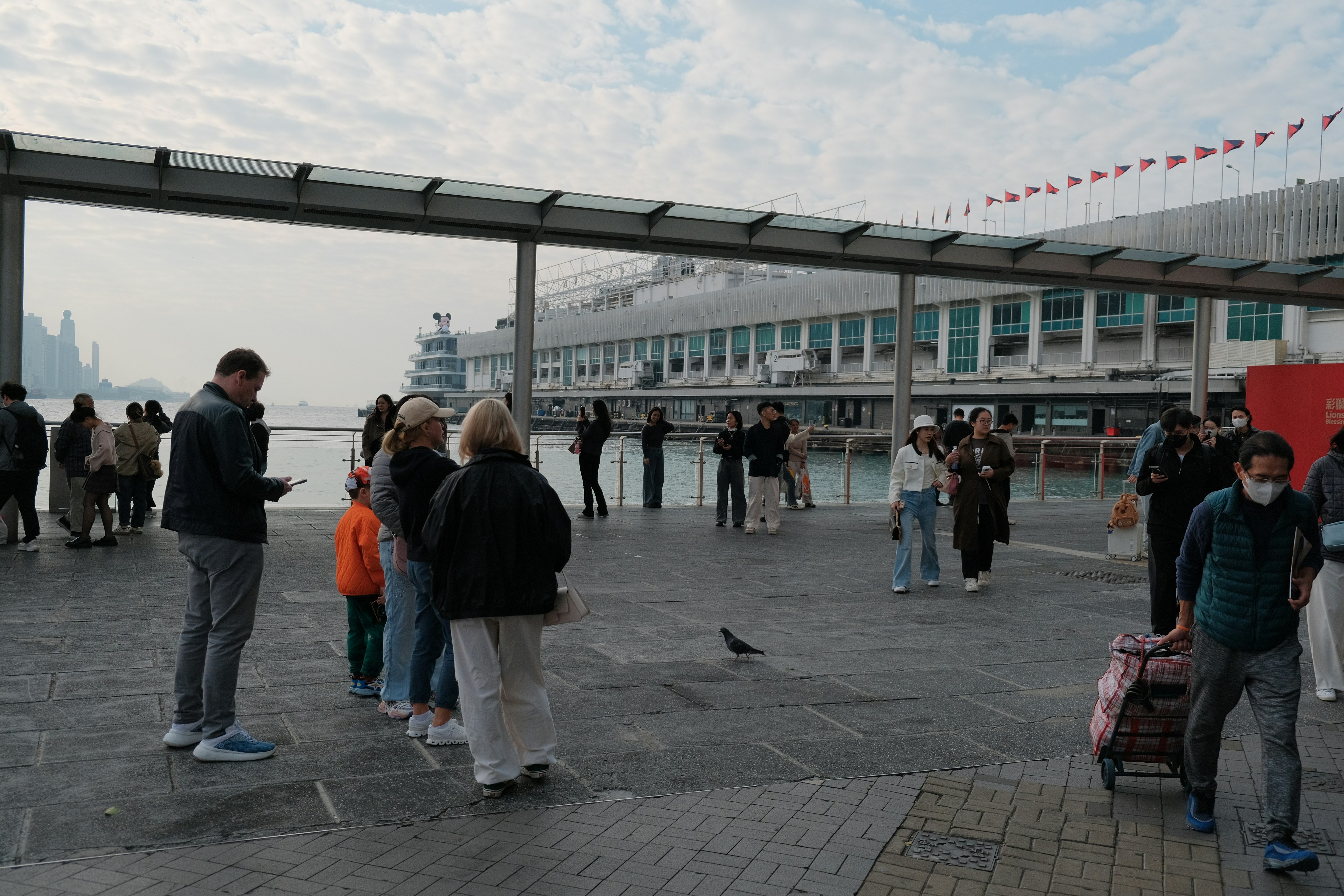 Quayside Moments: A Quiet Urban Gathering Beneath Glass and Flags