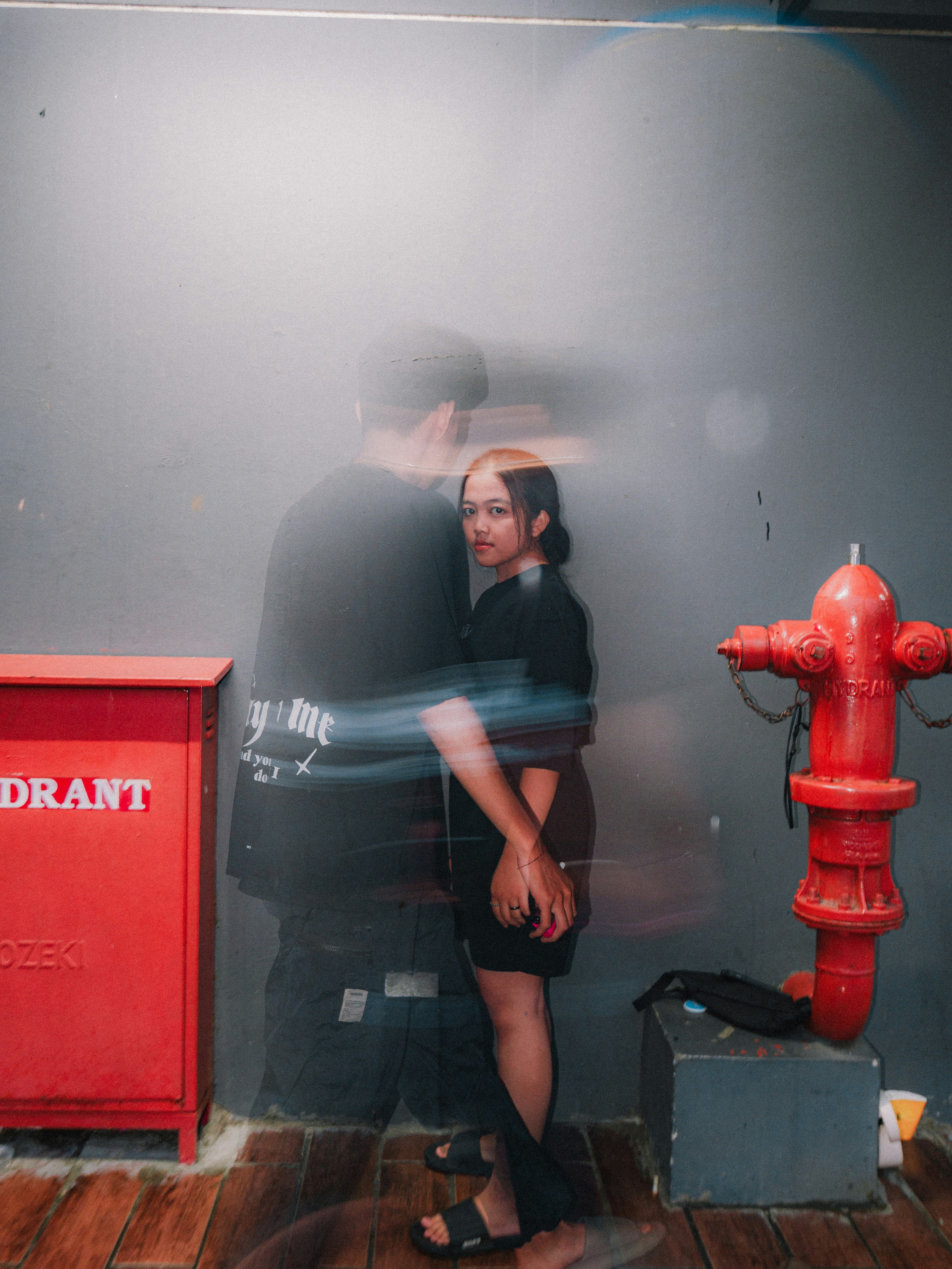 A woman standing next to a red fire hydrant photo – Free Woman Image on ...