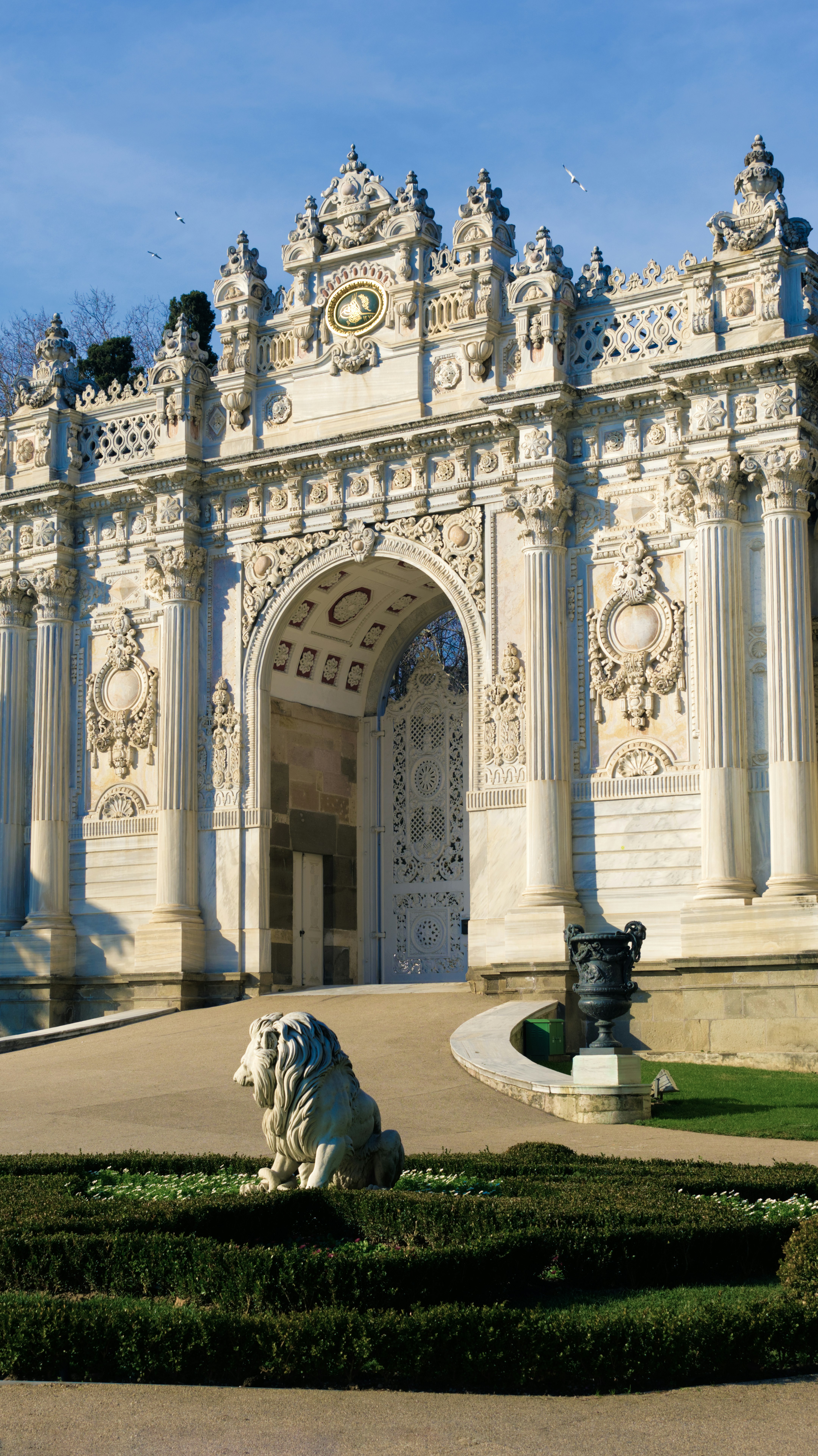 Sunlit Marble Gate: An Elaborate Carved Arch Framed by Guardian Lions