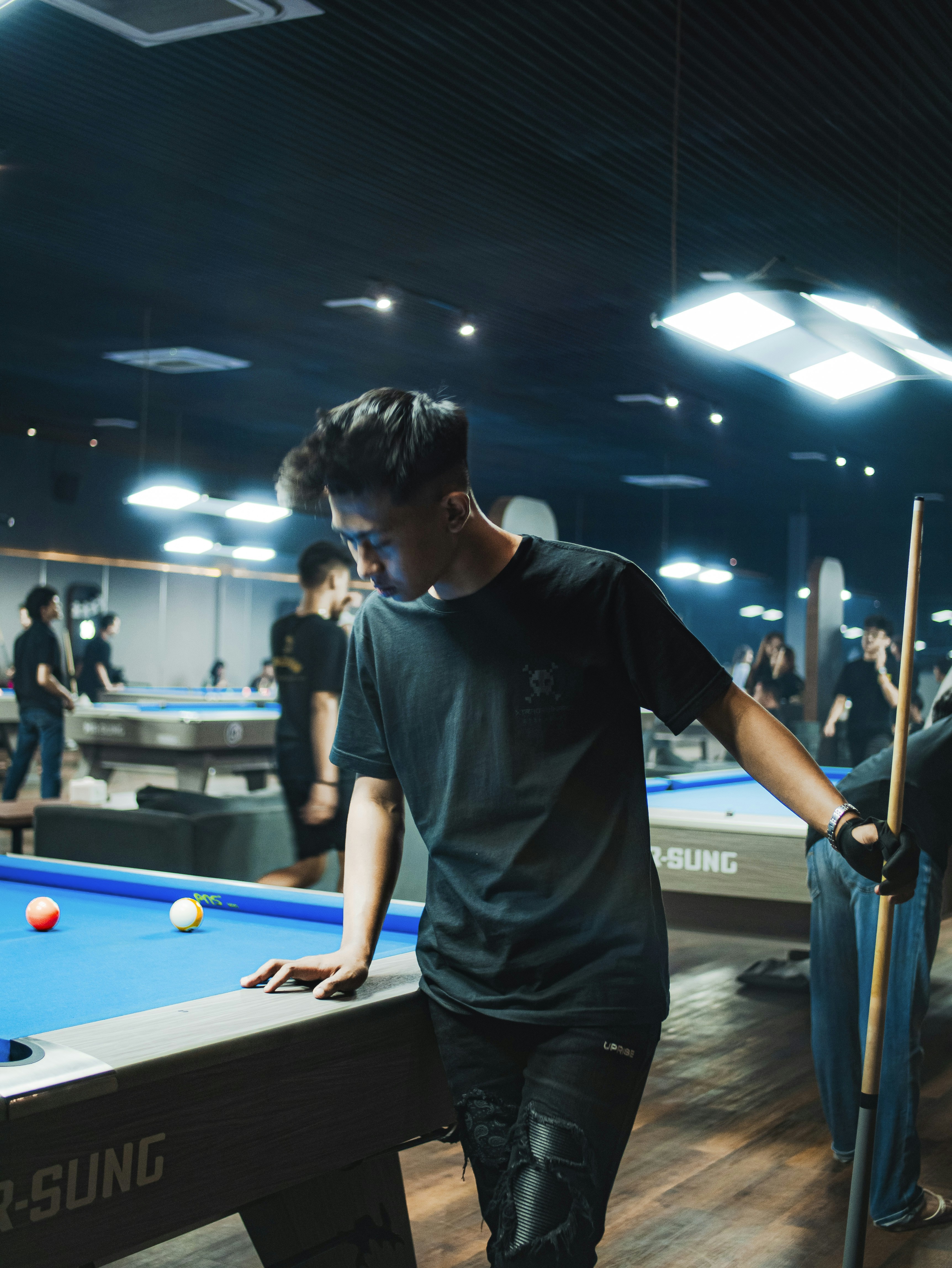 Lean Amid Neon: Focused Player at a Dim Pool Hall