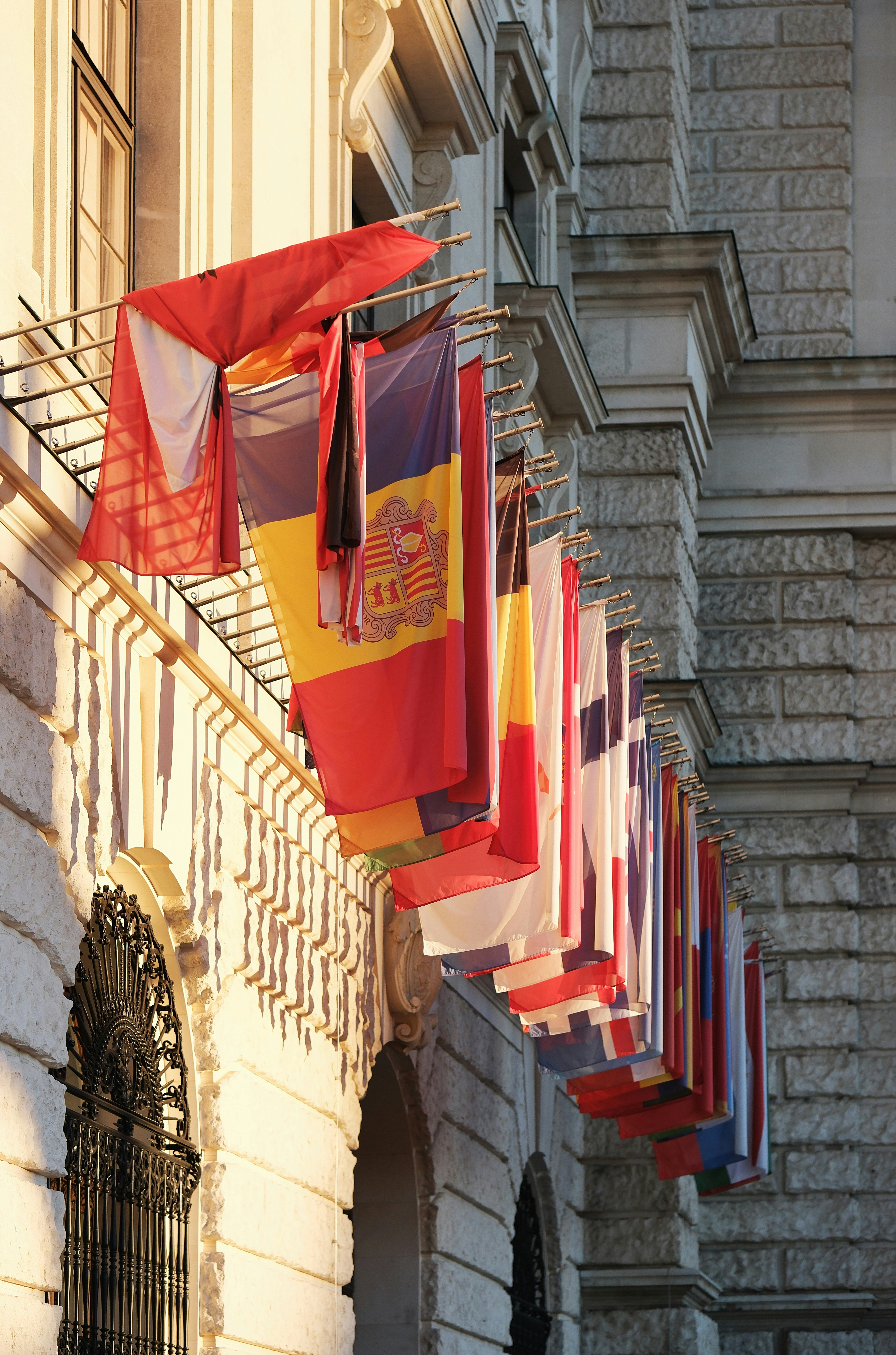 Golden Hour Flags: A Row of Nations on a Stone Facade