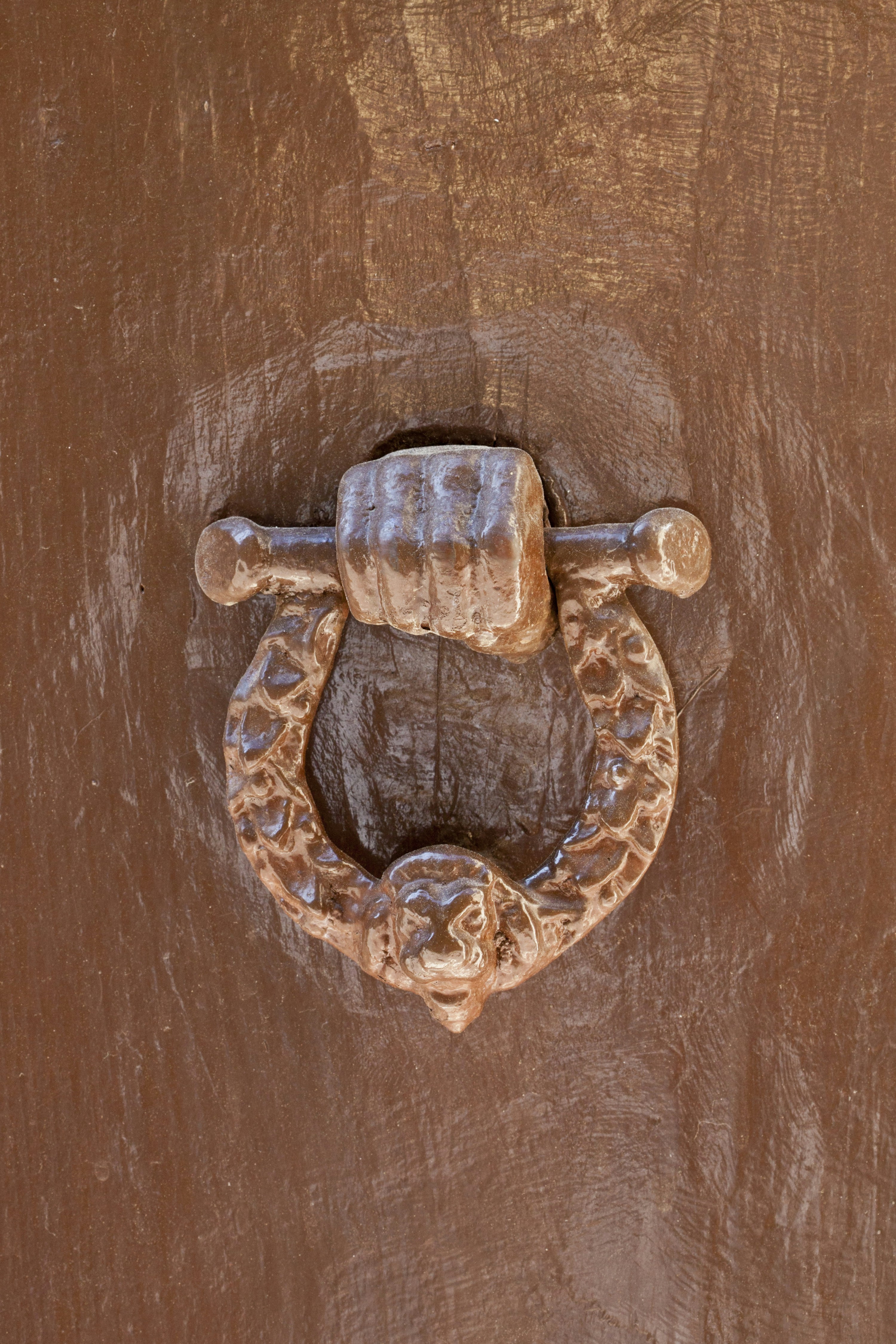 Handcrafted Iron Knocker on Time-Worn Wood: A Quiet Study in Texture