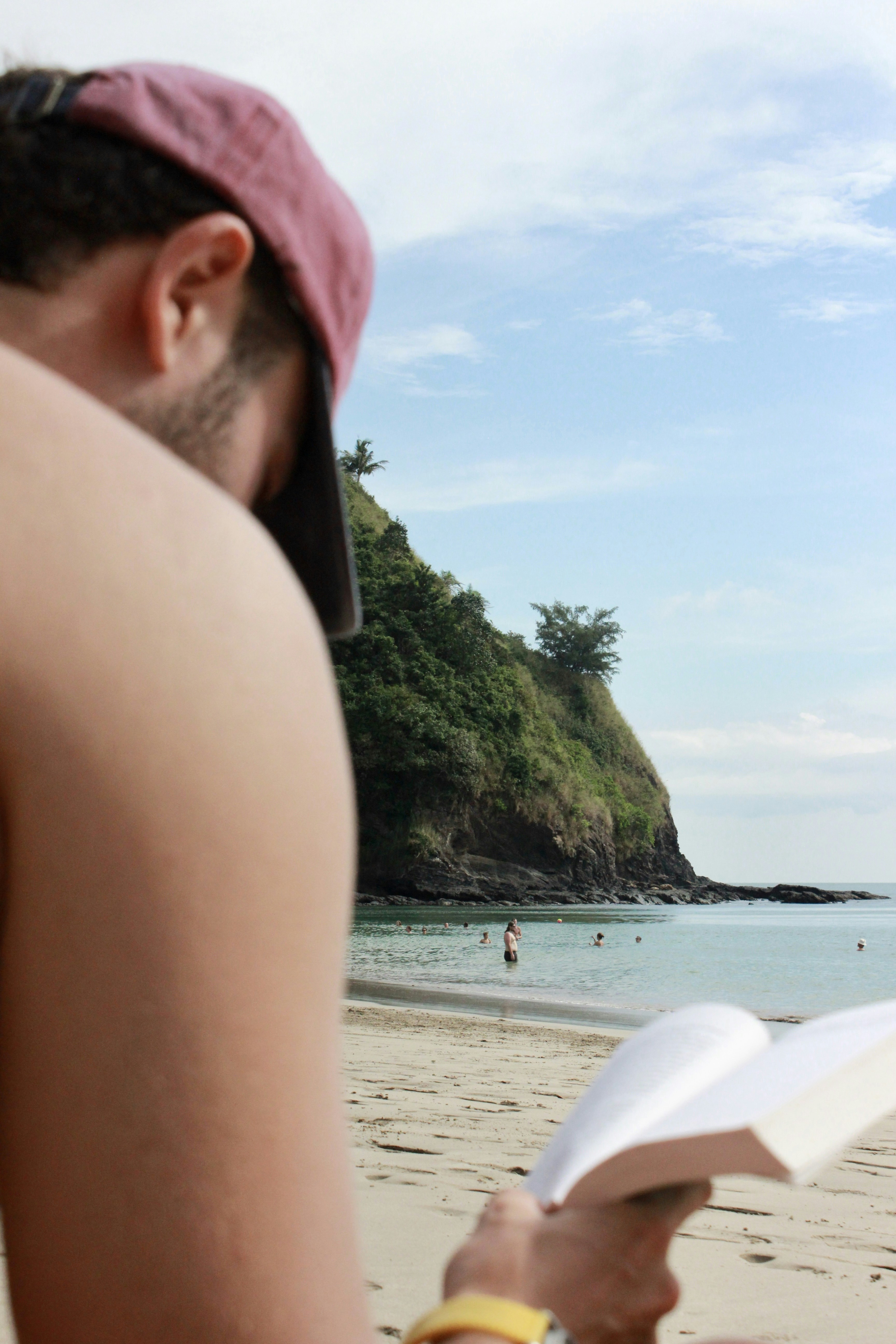 Beach Reader: a shaded figure at the edge of turquoise surf
