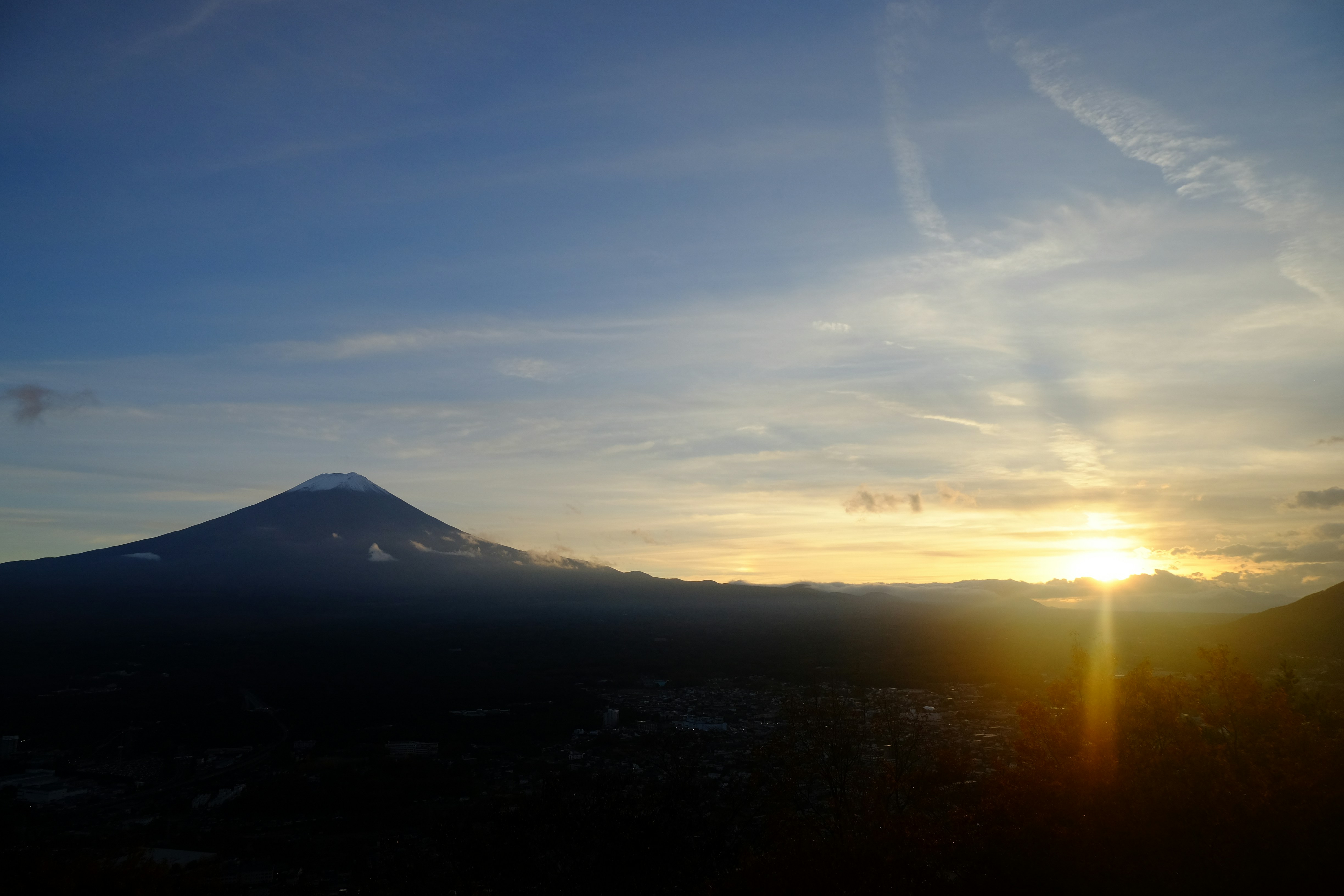 A view of a mountain with the sun setting behind it photo – Free Mount ...