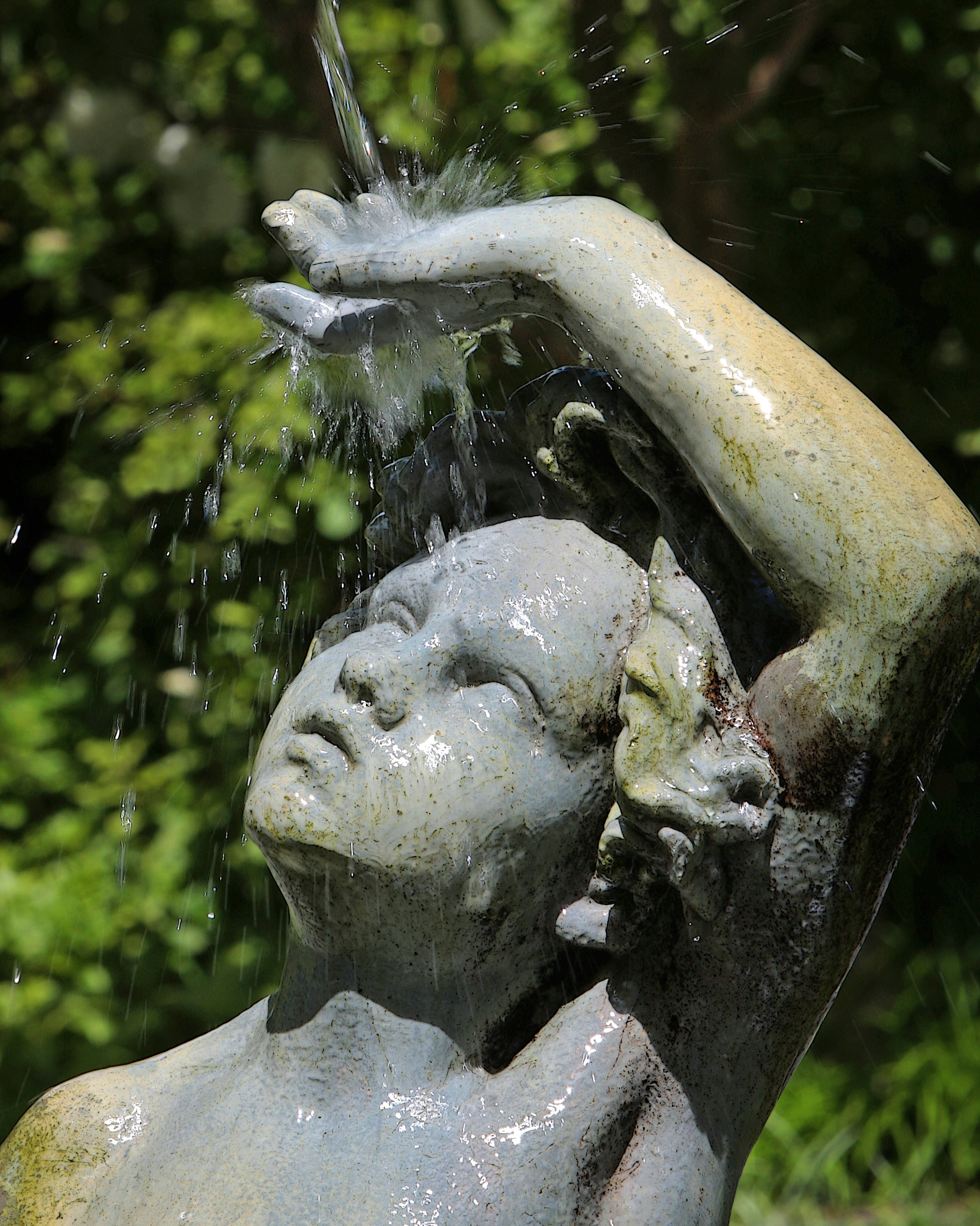 A statue of a boy is spouting water from his head photo – Free Rain ...