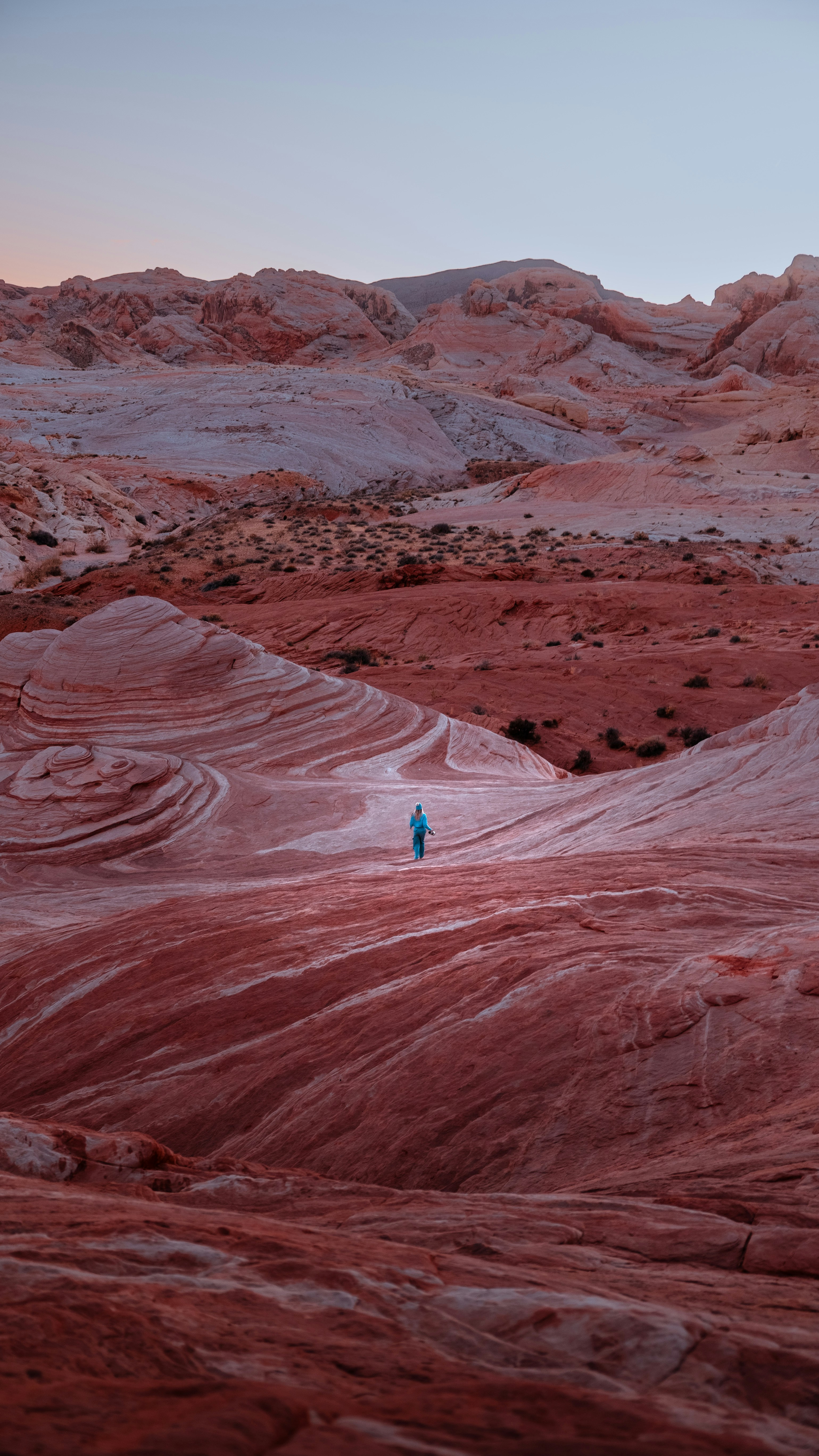 Blue-Clad Wanderer Amid Red Desert Rings